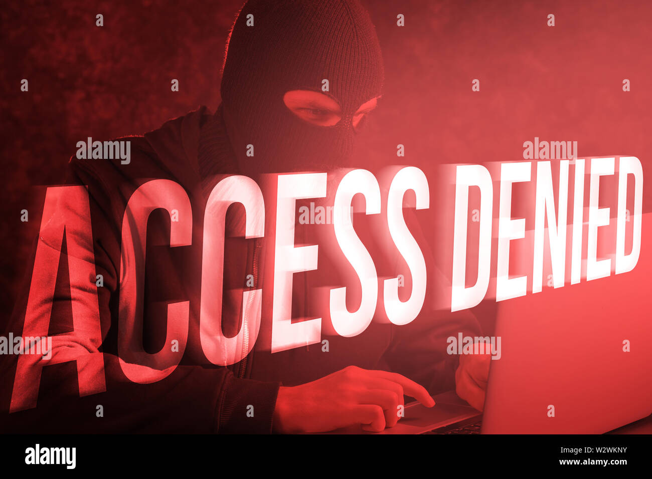 Male hacker with laptop and text ACCESS DENIED on color background ...