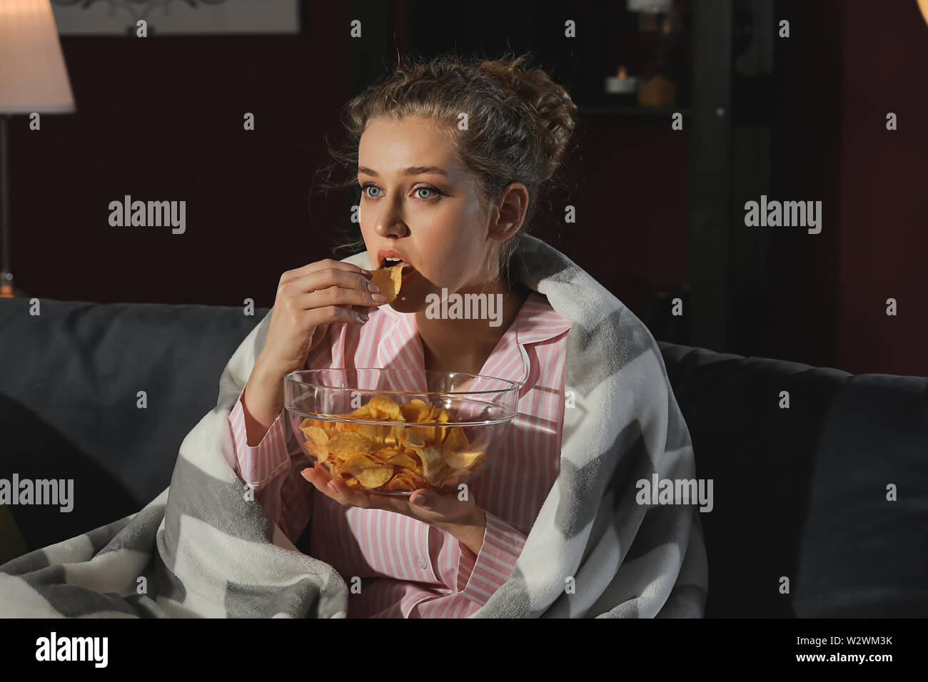 Beautiful young woman eating unhealthy food at night Stock Photo - Alamy