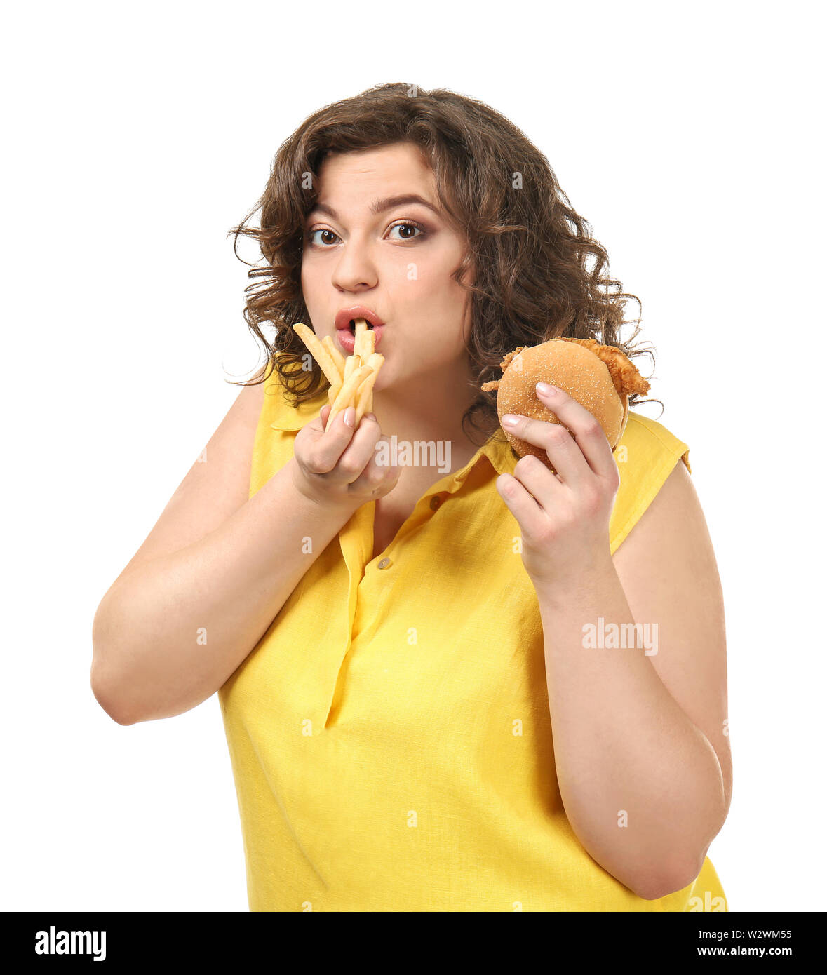 Overweight woman with burger and french fries on white background Stock ...