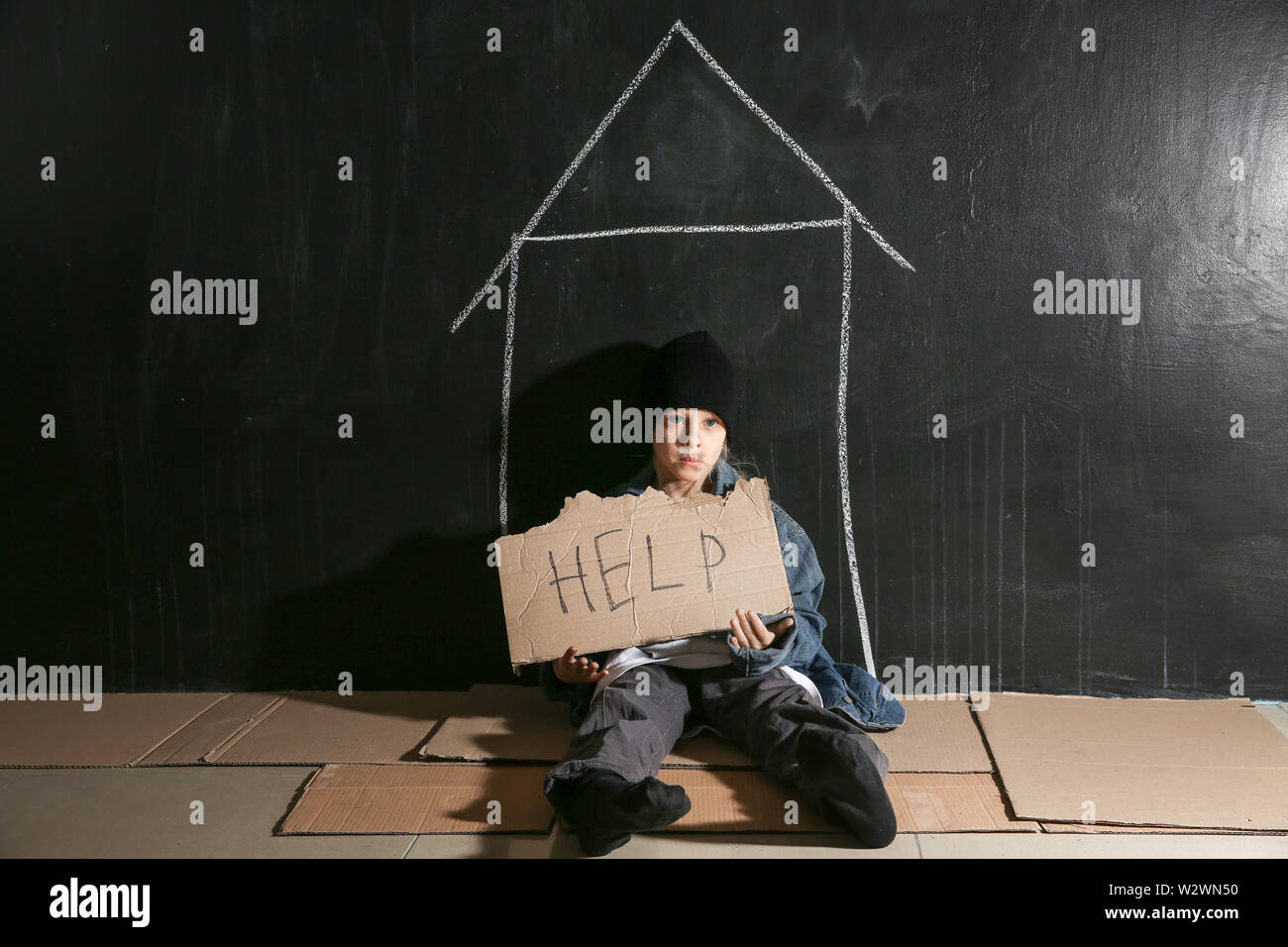 Homeless little girl begging for help near dark wall Stock Photo - Alamy