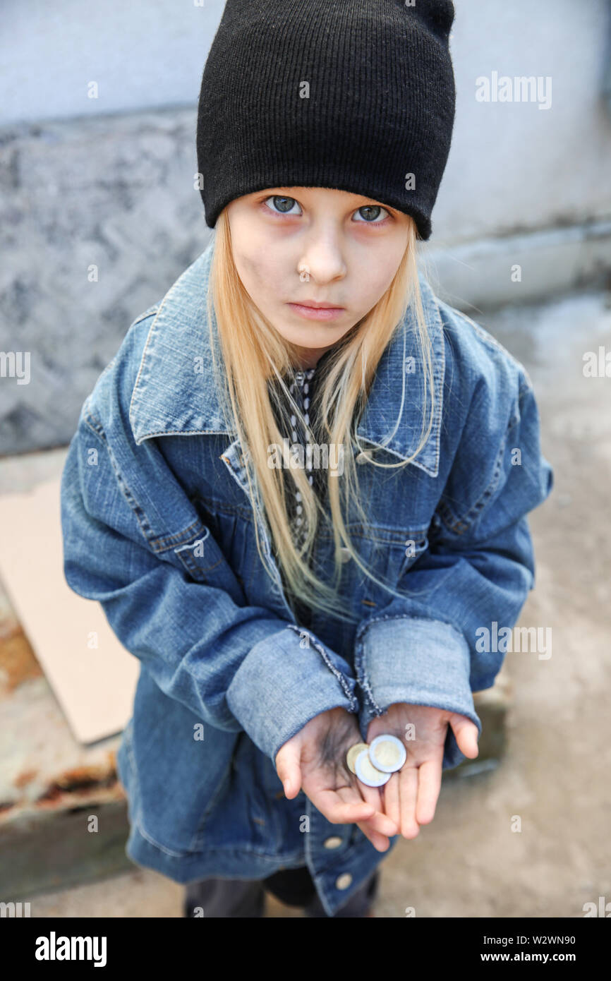 Homeless little girl with coins outdoors Stock Photo - Alamy