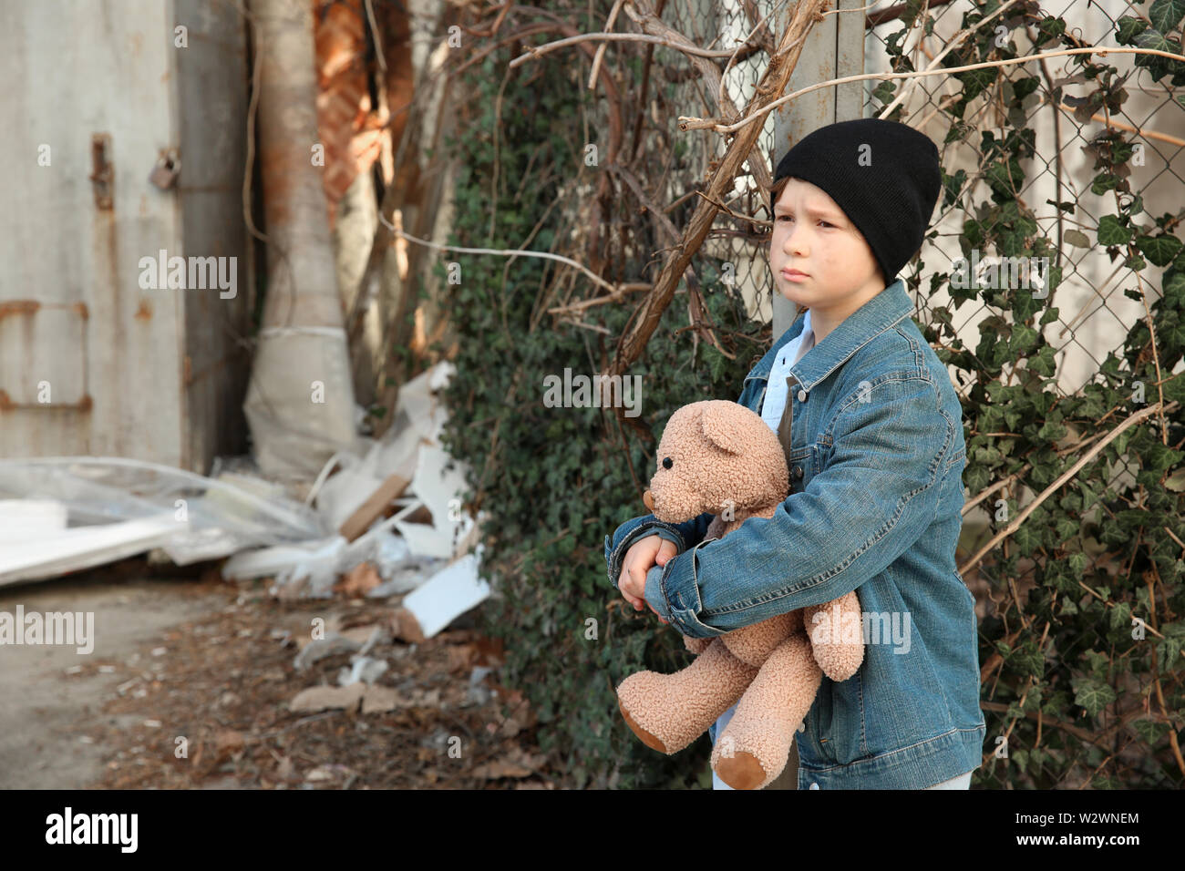 Homeless little boy with teddy bear outdoors Stock Photo - Alamy