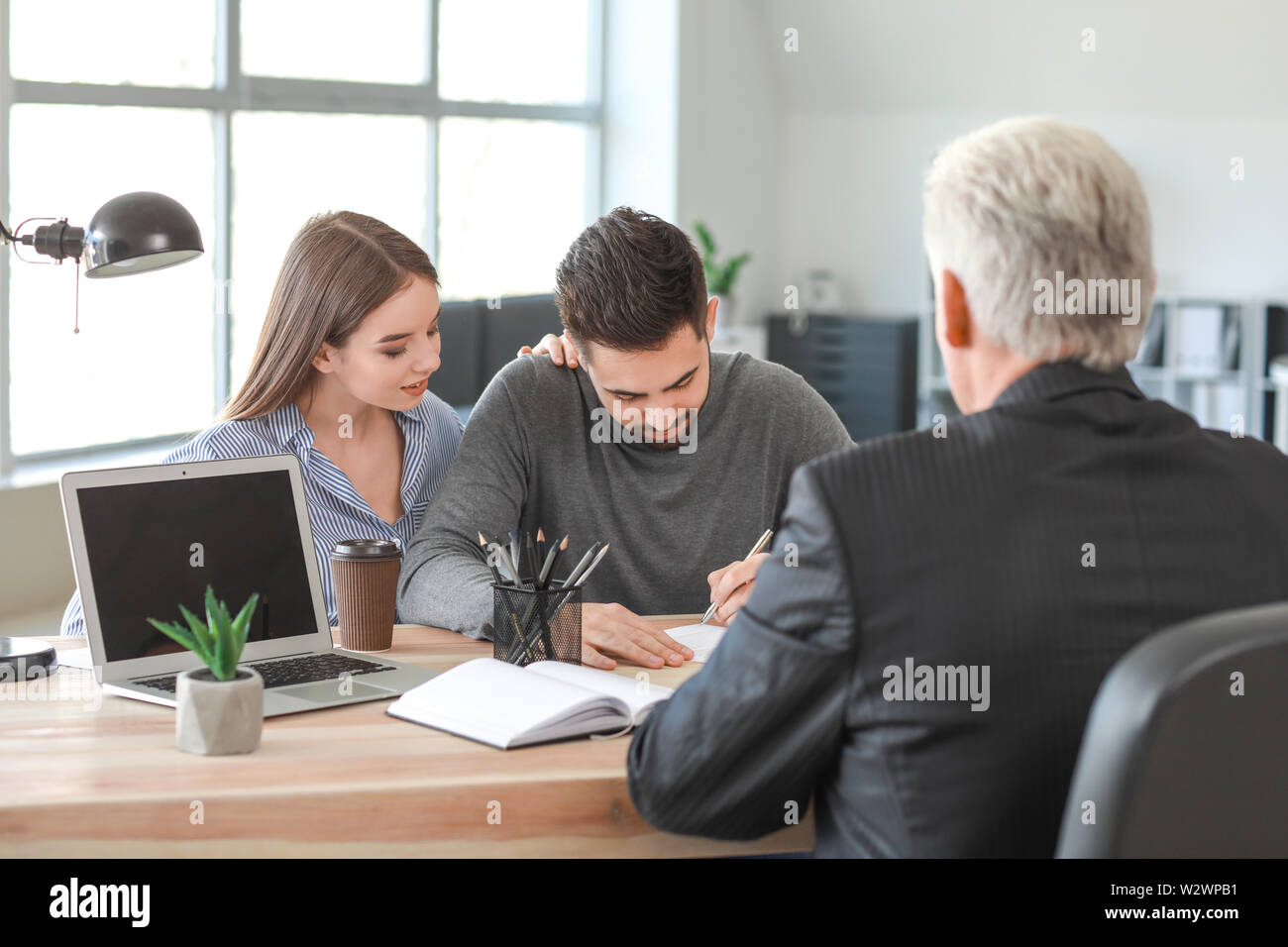 Couple signing documents at notary public office Stock Photo - Alamy
