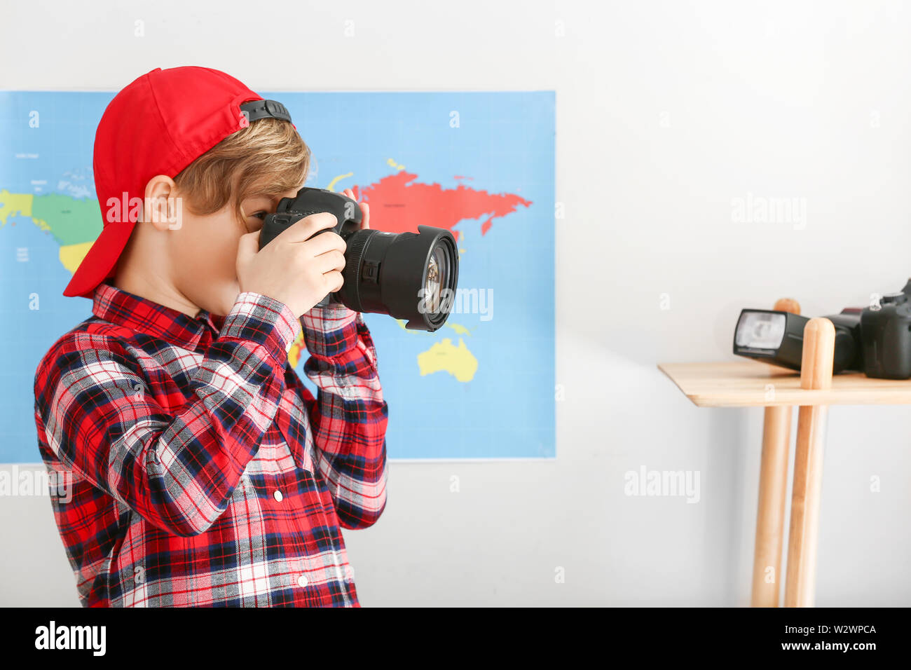 Cute little photographer with professional camera at home Stock Photo ...