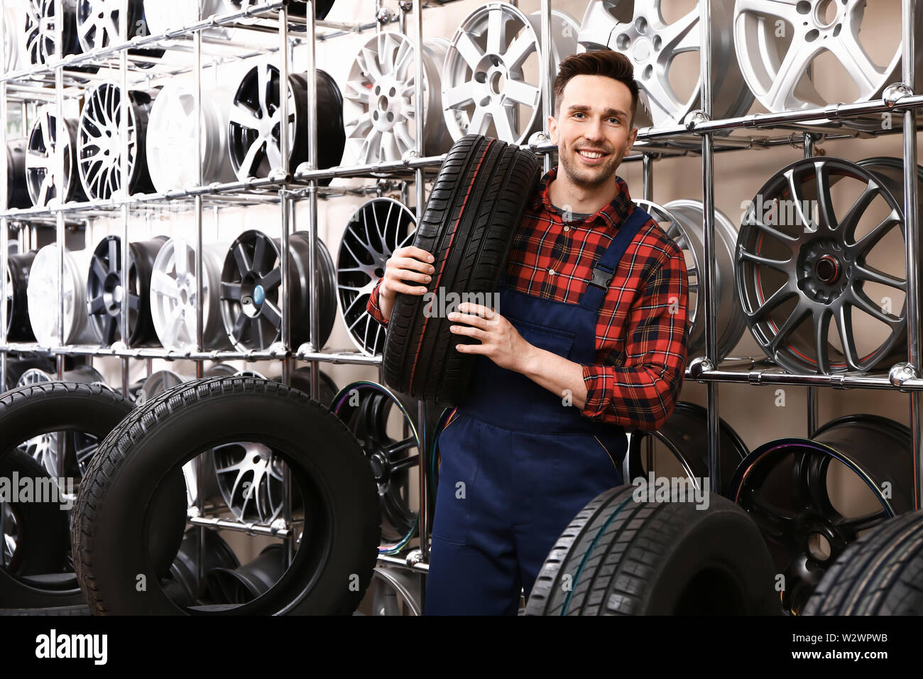 Male seller in car tire store Stock Photo - Alamy