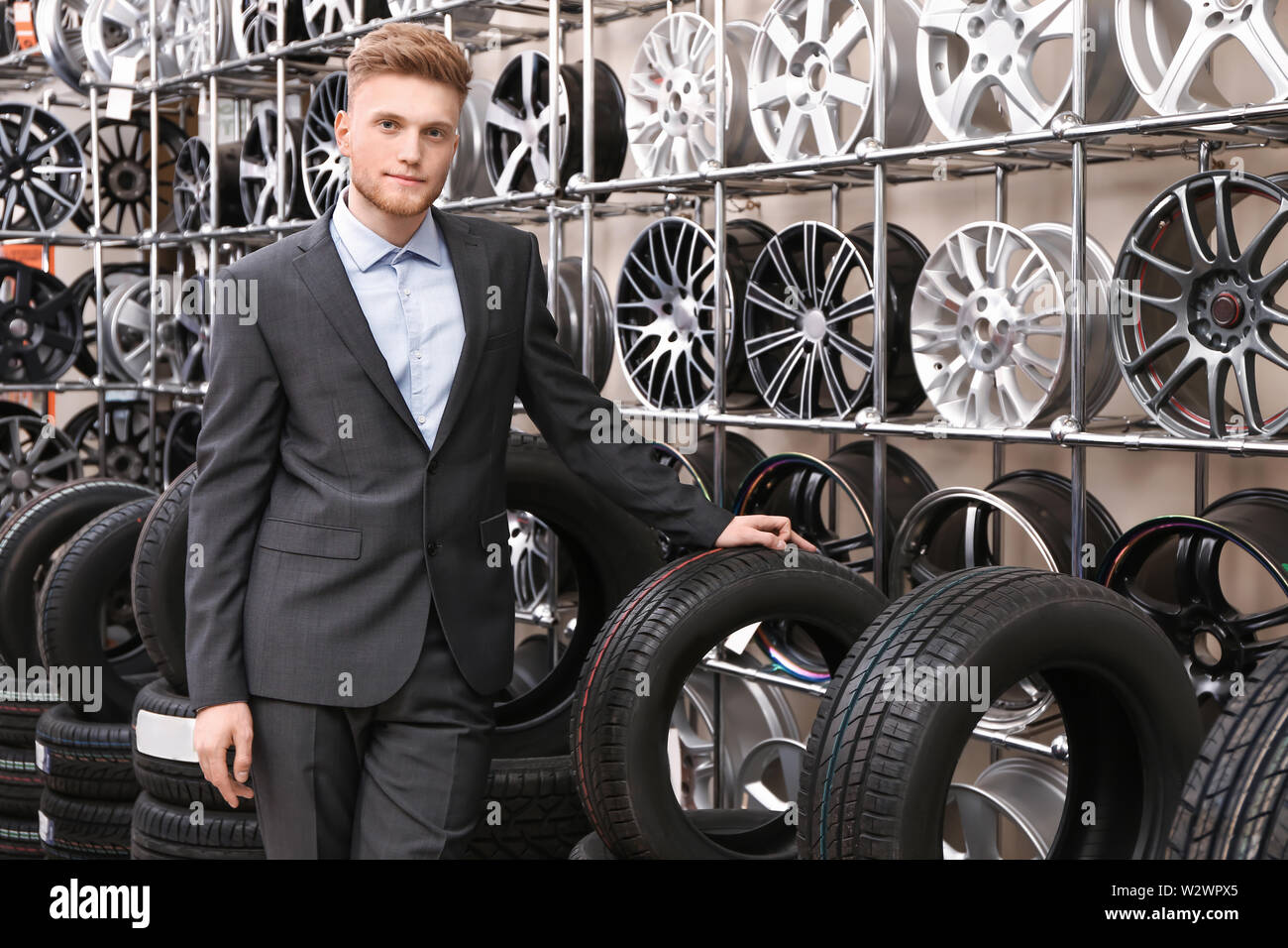 Male seller in car tire store Stock Photo - Alamy