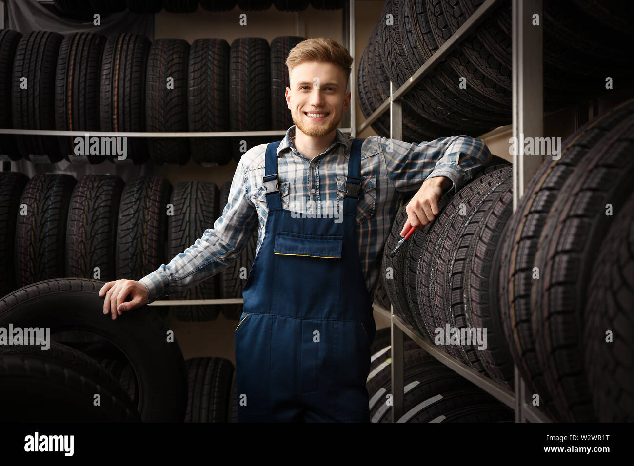 Male seller in car tire store Stock Photo - Alamy