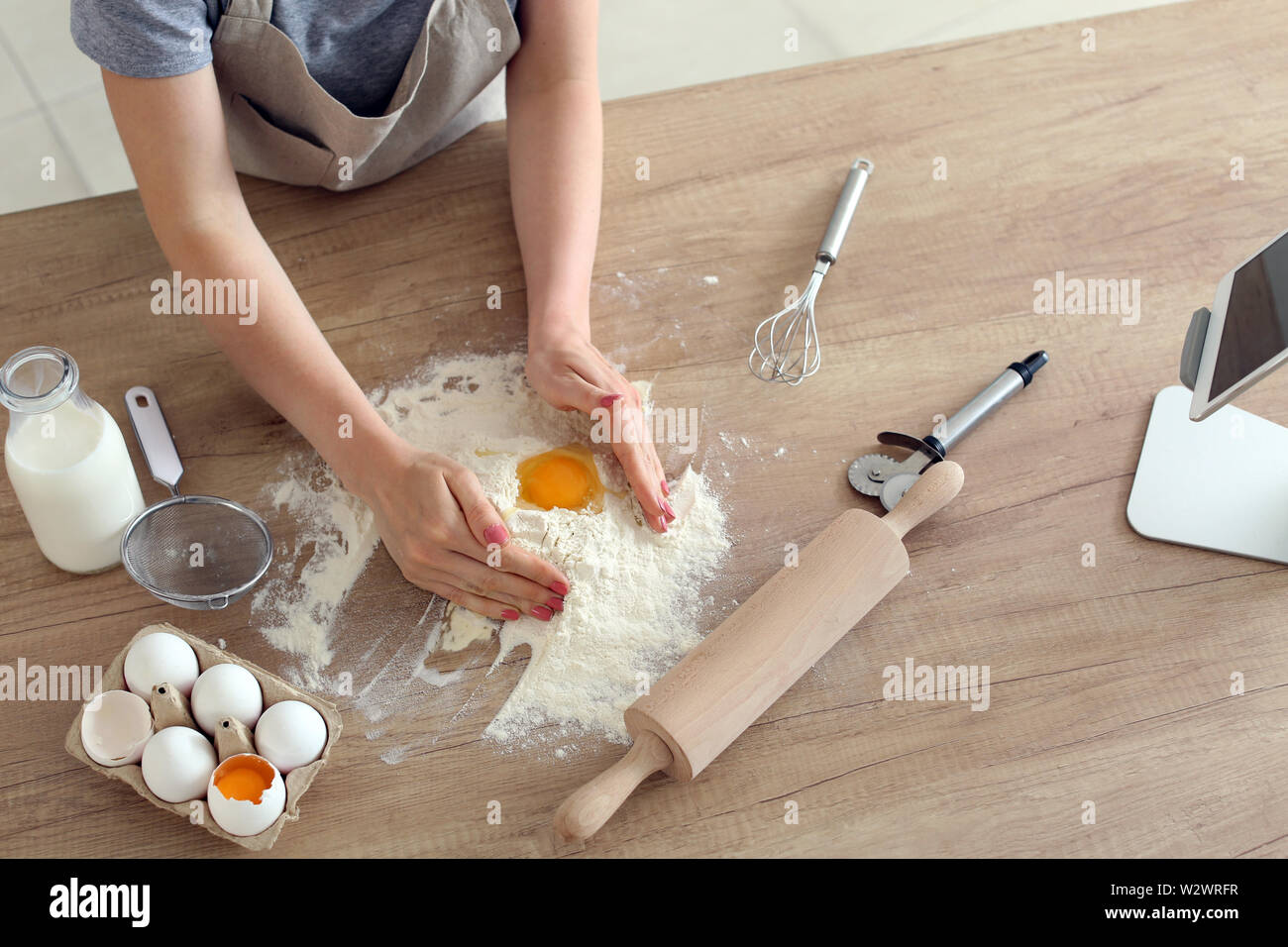 Beautiful young woman cooking pastry in kitchen Stock Photo - Alamy