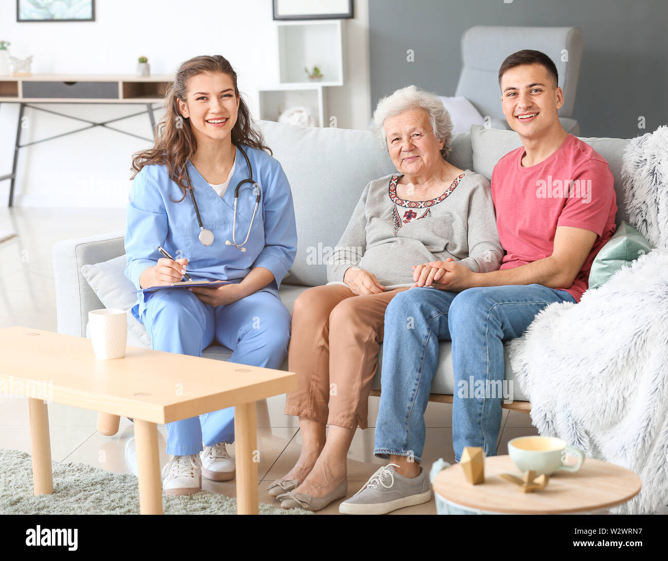 Caregiver visiting senior woman at home Stock Photo - Alamy