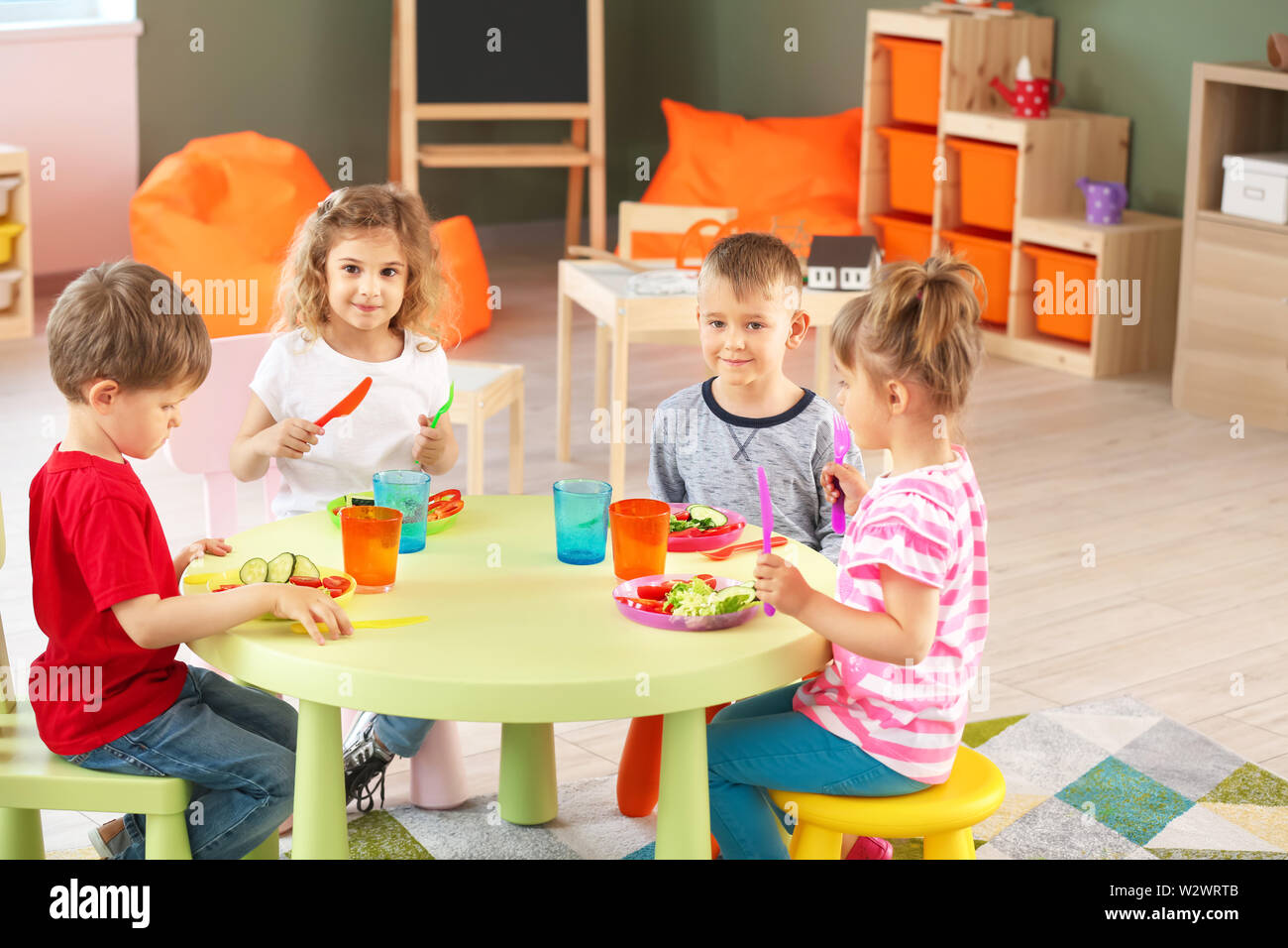 Cute little children eating tasty lunch in kindergarten Stock Photo - Alamy