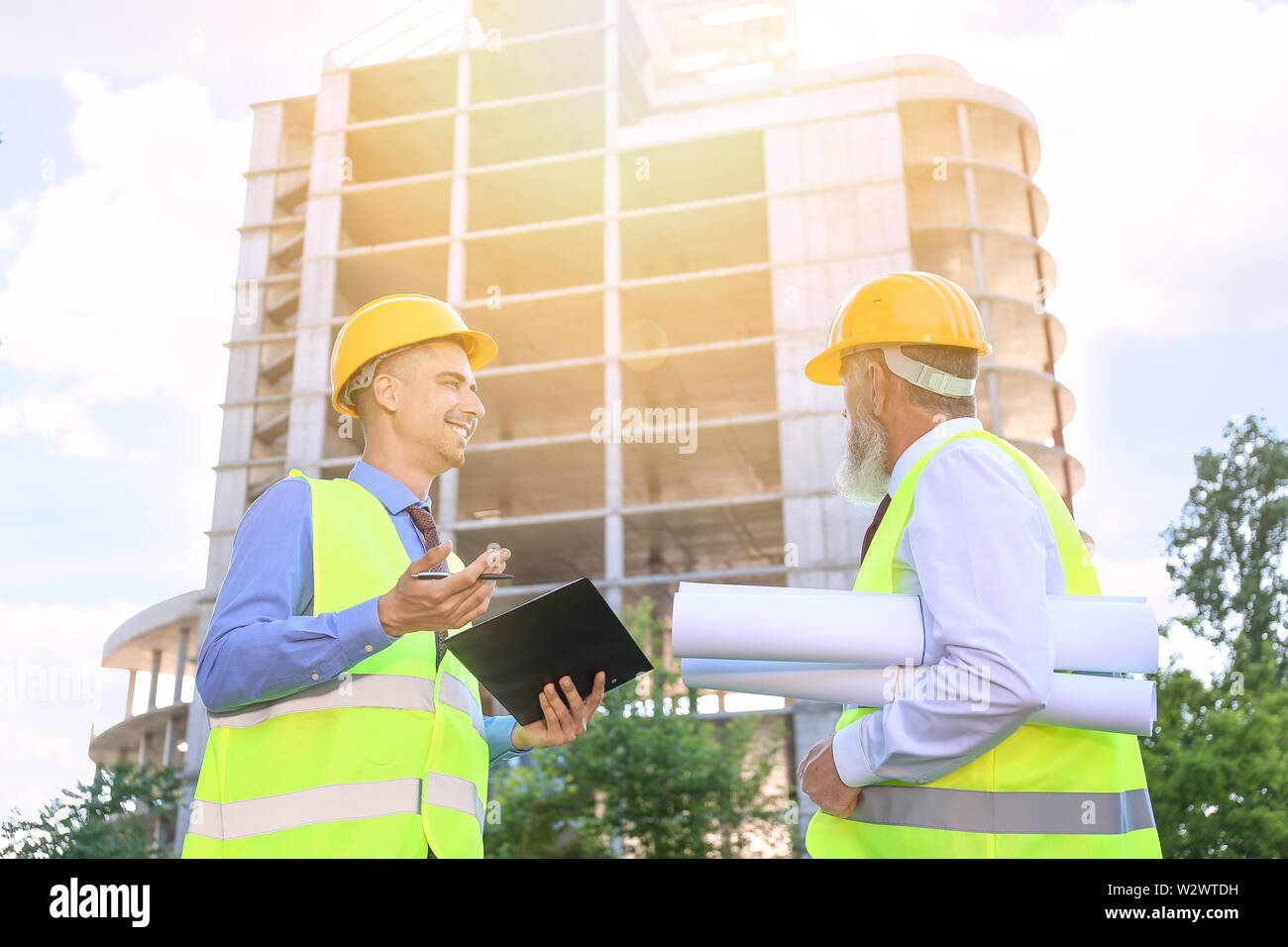 Architects discussing project of building outdoors Stock Photo - Alamy