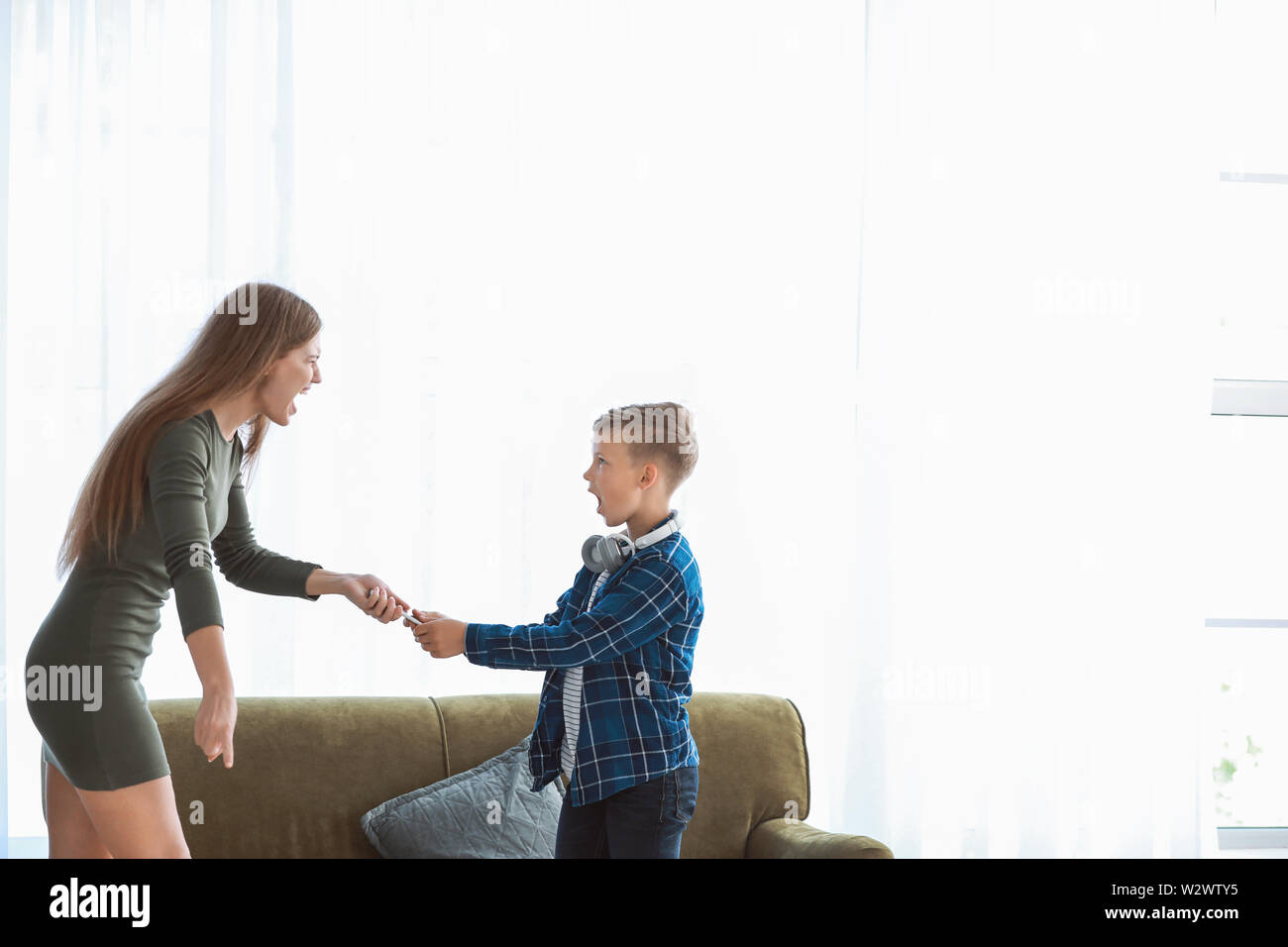 Mother taking mobile phone from her son with addiction to modern ...
