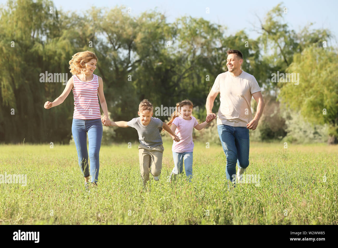 Happy family running in park on summer day Stock Photo - Alamy