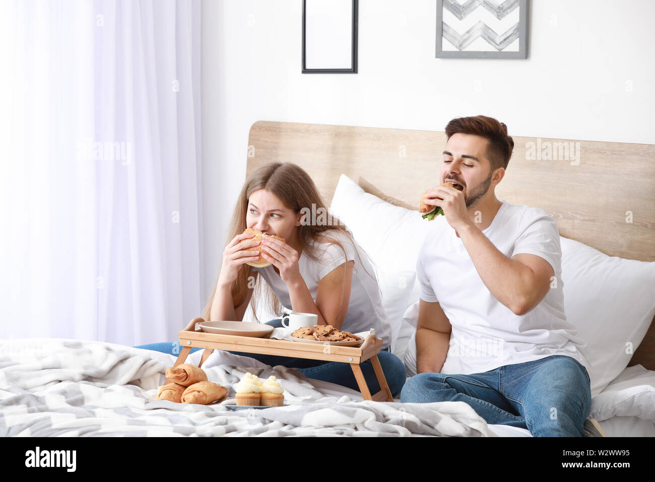Couple sitting on bed eating hi-res stock photography and images - Alamy
