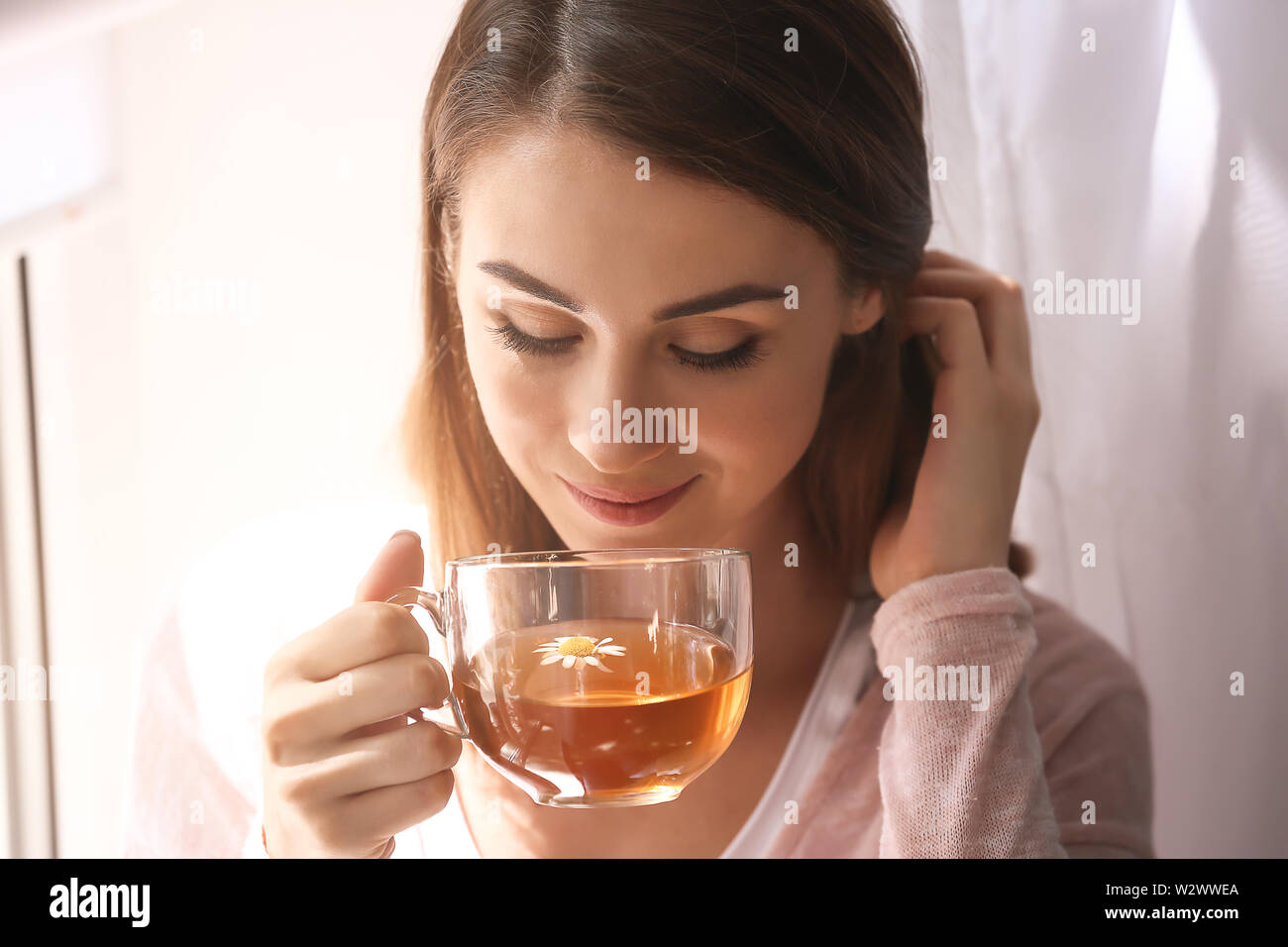 Beautiful young woman drinking tea at home Stock Photo - Alamy