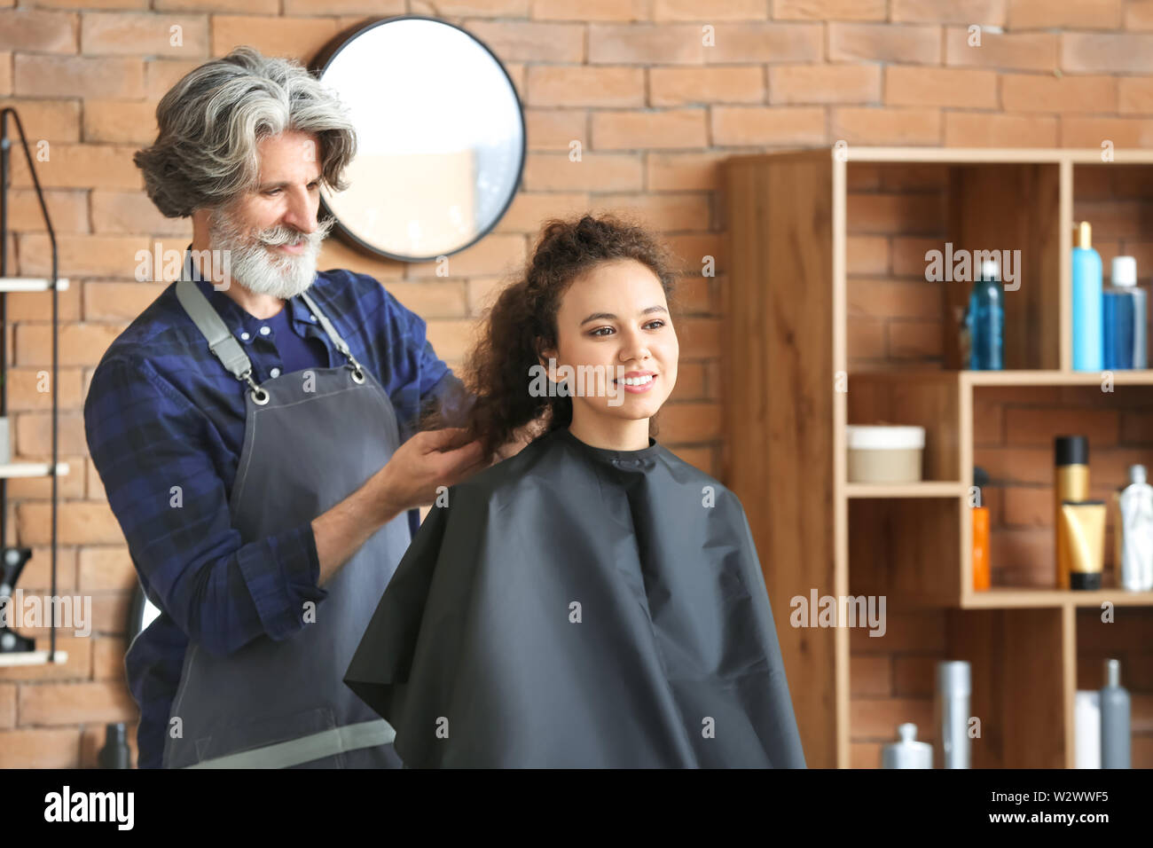 Professional hairdresser working with client in beauty salon Stock ...
