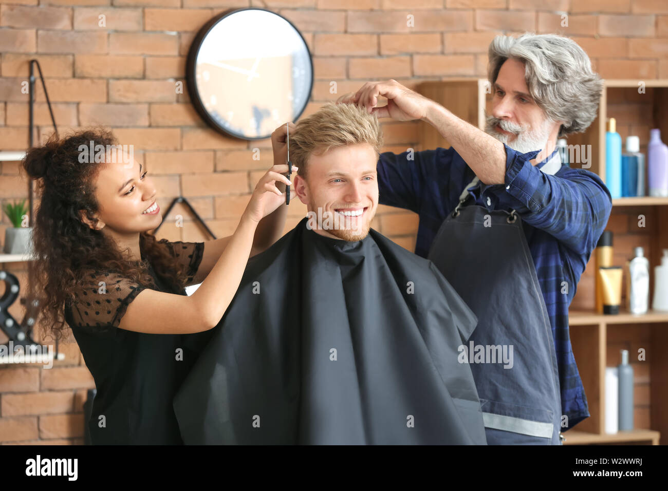 Professional hairdressers working with client in beauty salon Stock ...