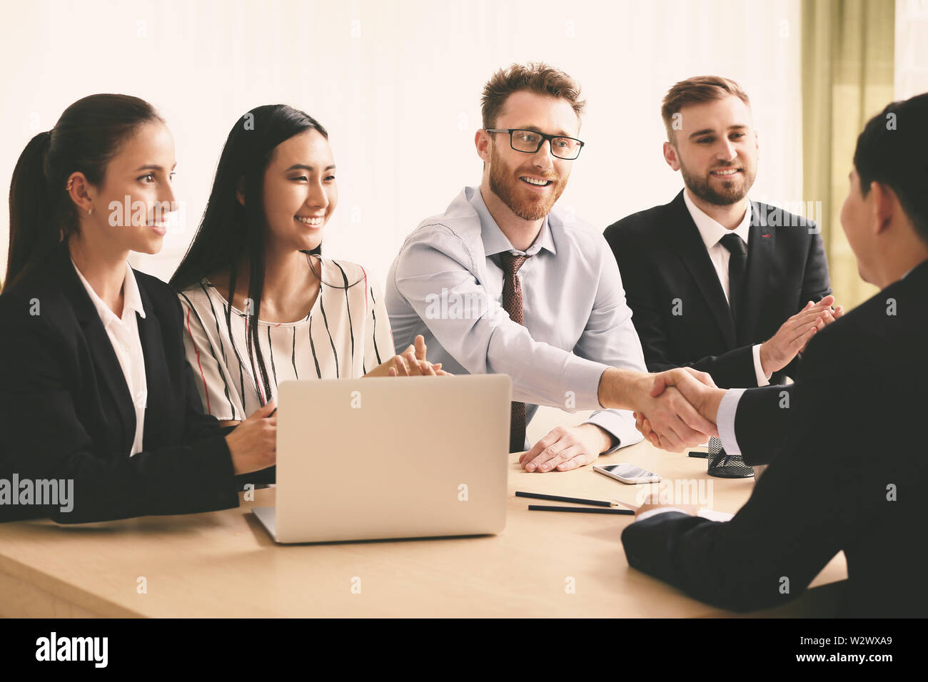 Human resources manager shaking hands with applicant after successful ...