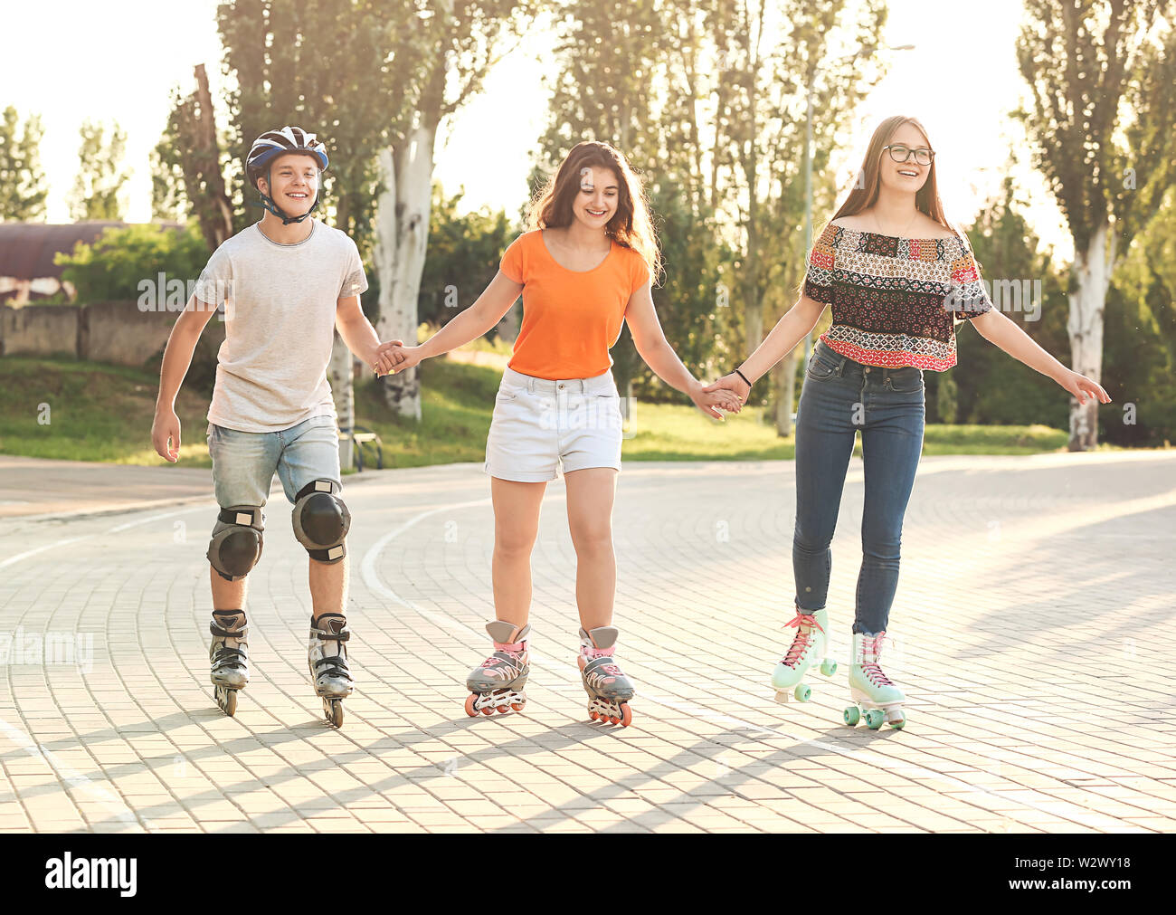 Teenagers on roller skates outdoors Stock Photo - Alamy