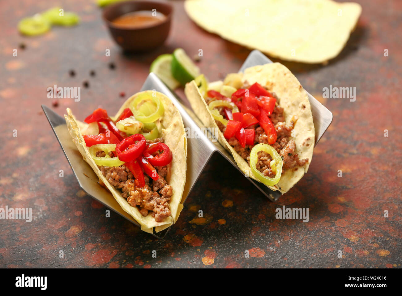 Stand with tasty fresh tacos on grunge background Stock Photo - Alamy