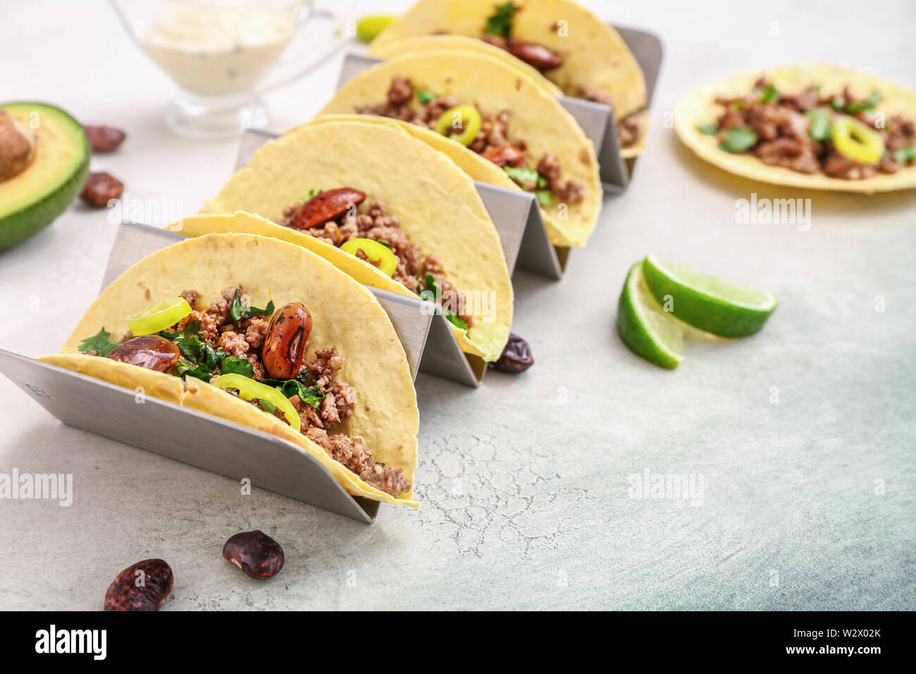 Stand with tasty fresh tacos on light background Stock Photo - Alamy