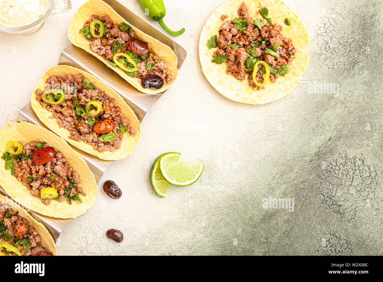 Stand with tasty fresh tacos on light background Stock Photo - Alamy