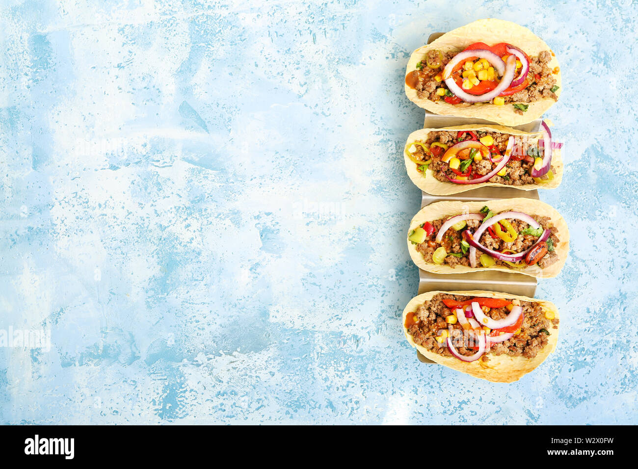 Stand with tasty fresh tacos on color background Stock Photo - Alamy