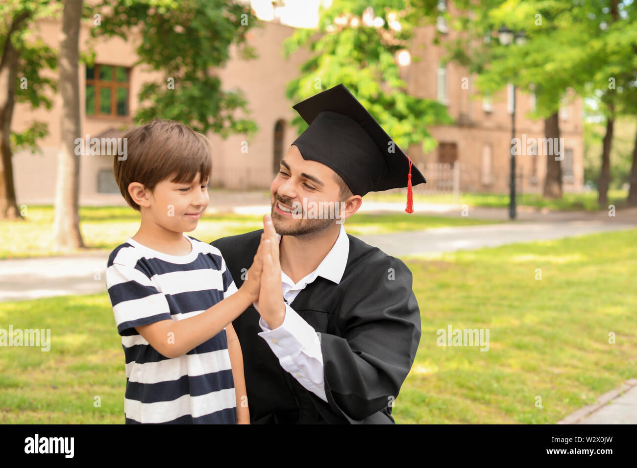 Man with his little son on graduation day Stock Photo - Alamy