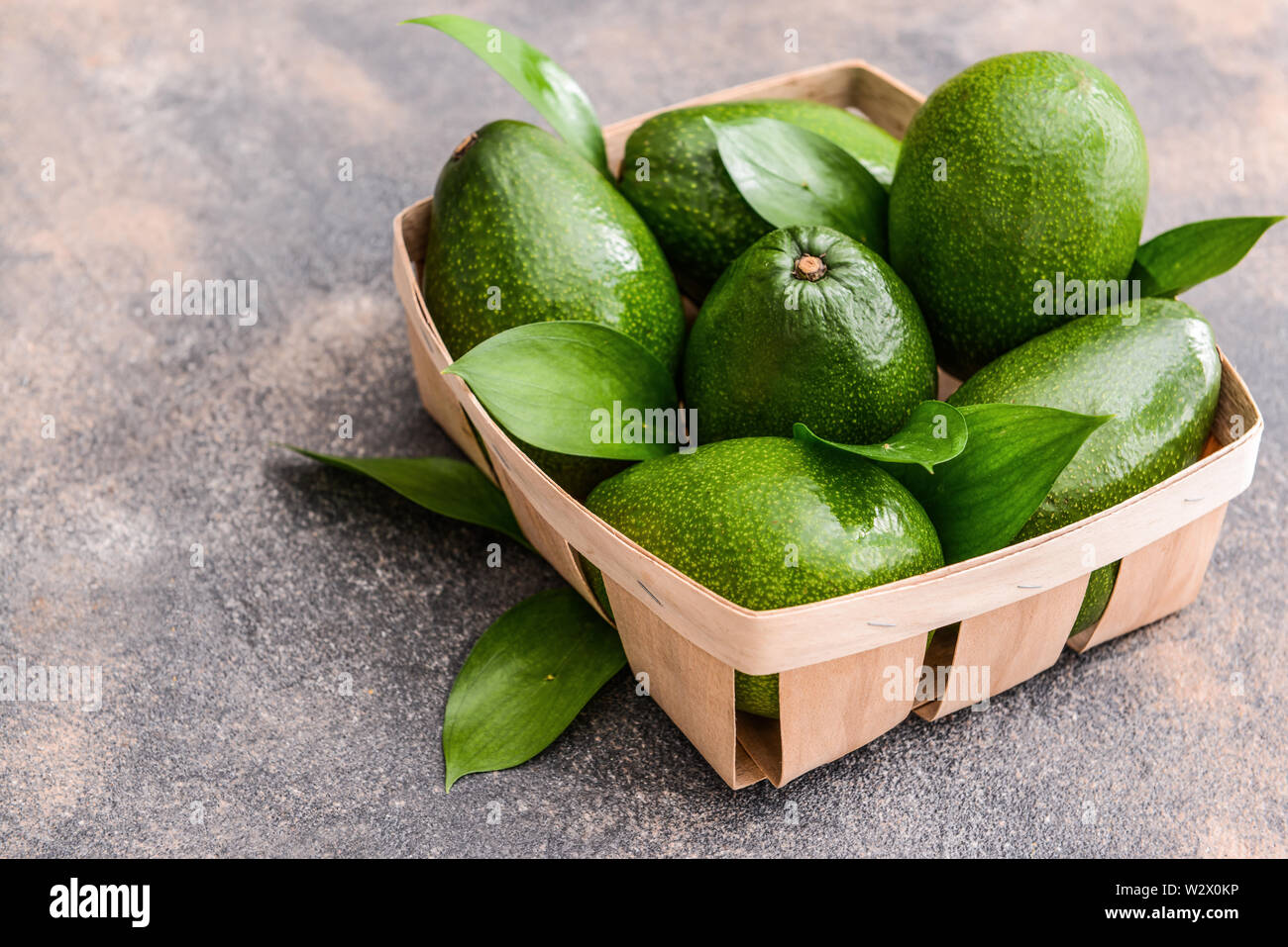 Box with fresh ripe avocados on grey background Stock Photo - Alamy