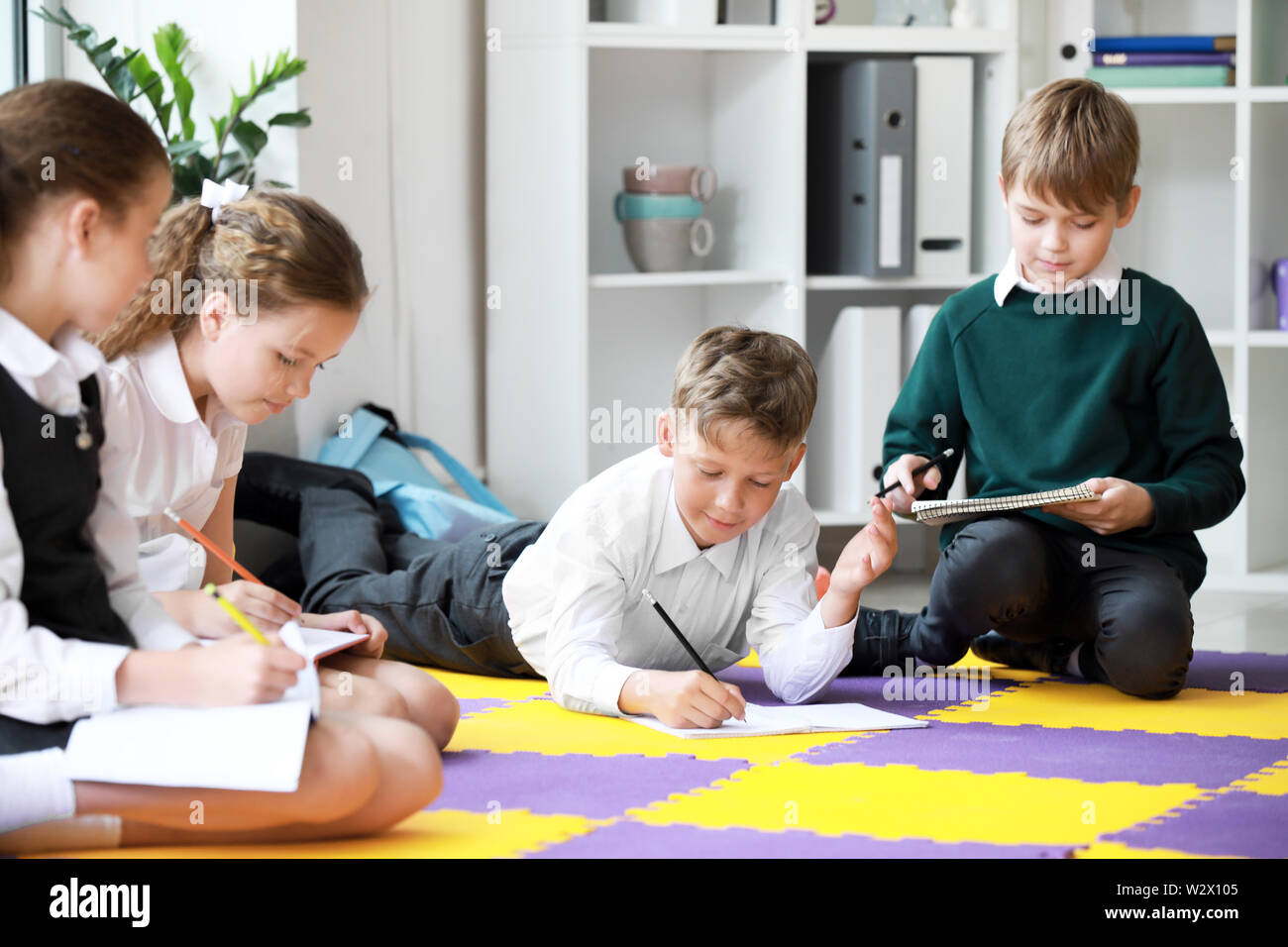 Cute little children doing lessons in classroom Stock Photo - Alamy