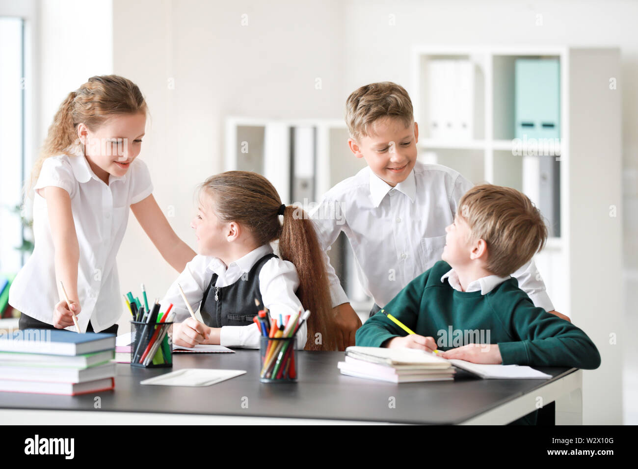 Cute little children doing lessons in classroom Stock Photo - Alamy