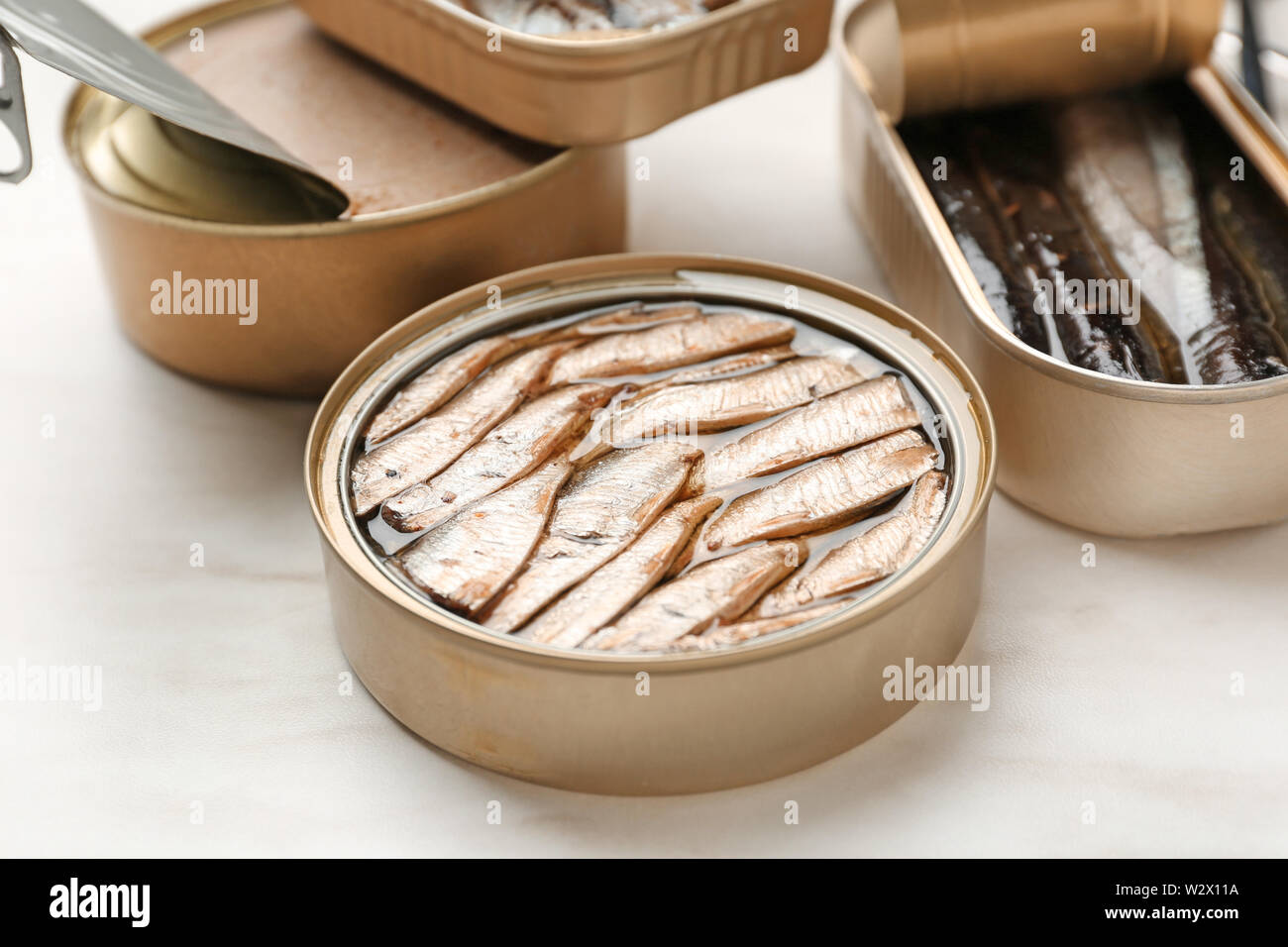 Tin cans with different food on light background Stock Photo - Alamy