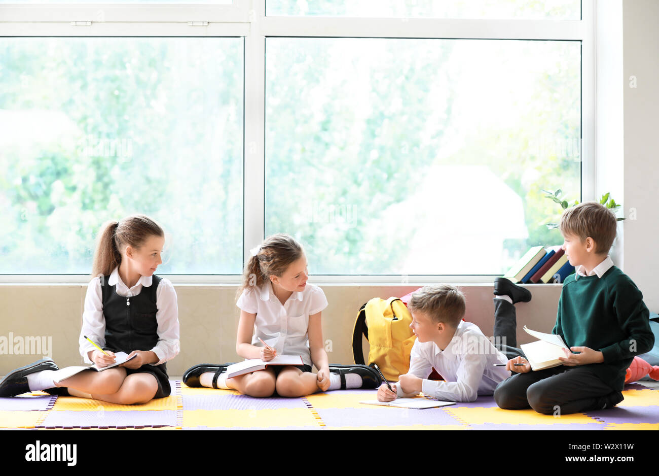 Cute little children doing lessons in classroom Stock Photo - Alamy