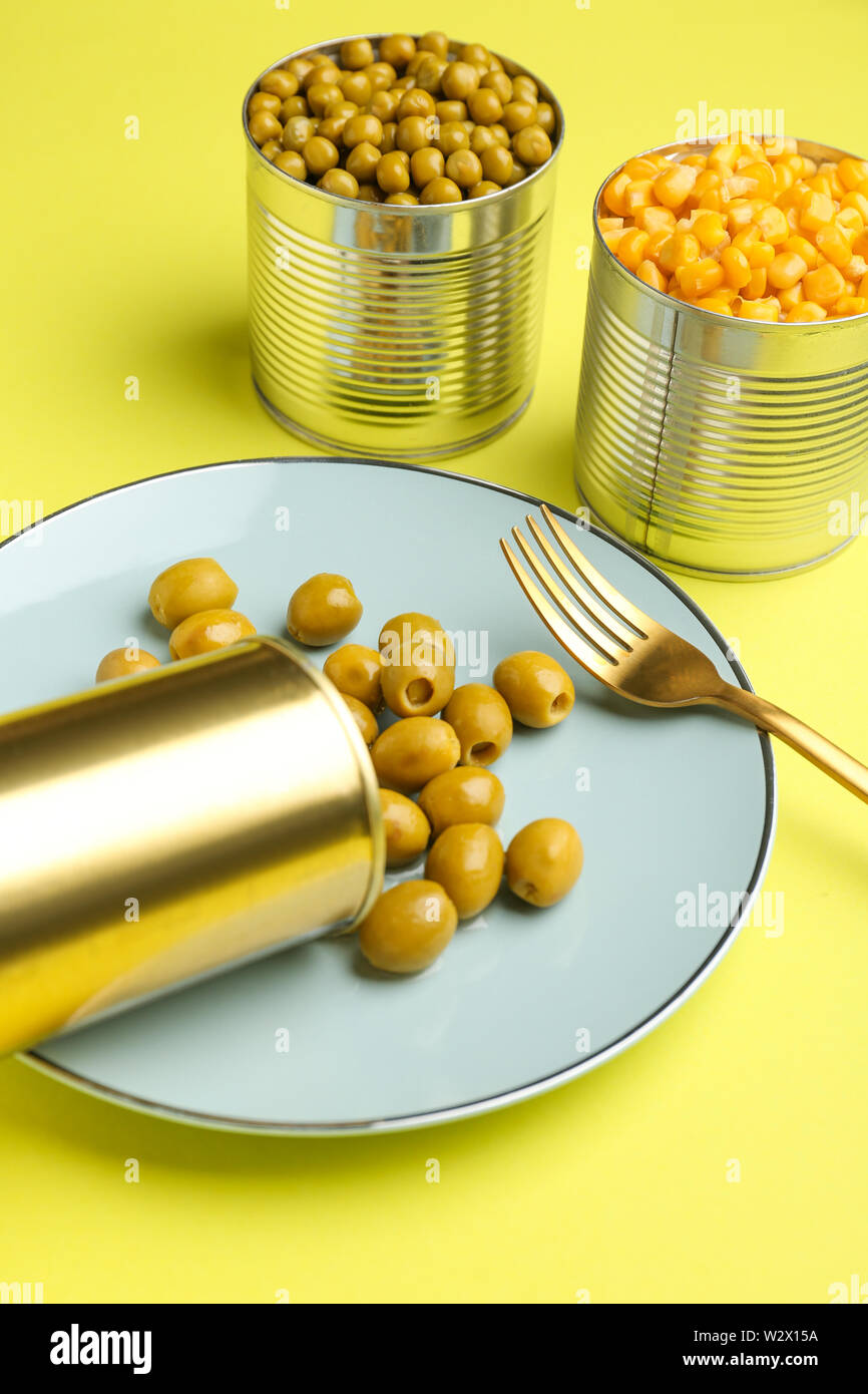Tin cans with different food on color background Stock Photo - Alamy