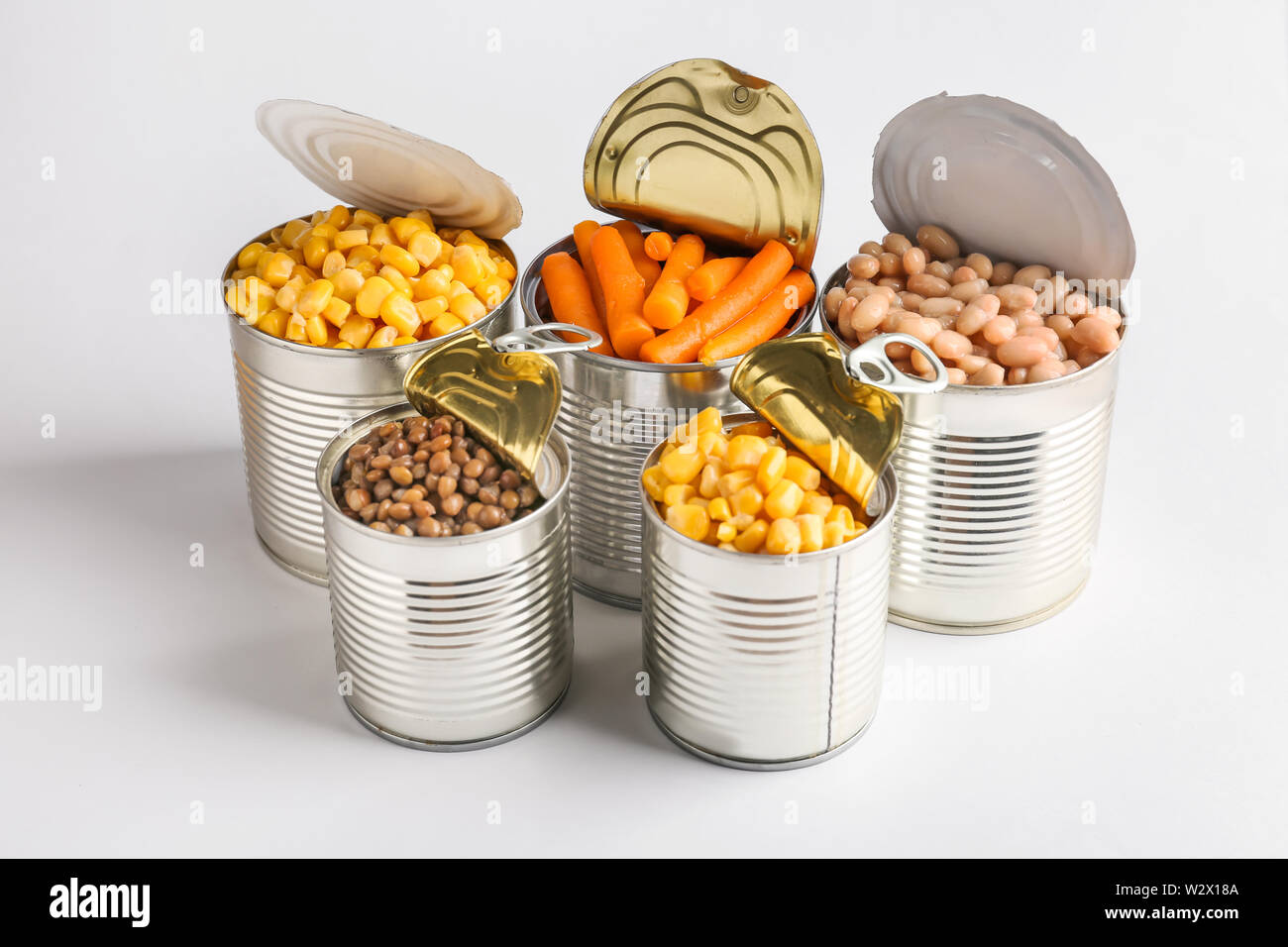 Tin cans with different food on light background Stock Photo - Alamy