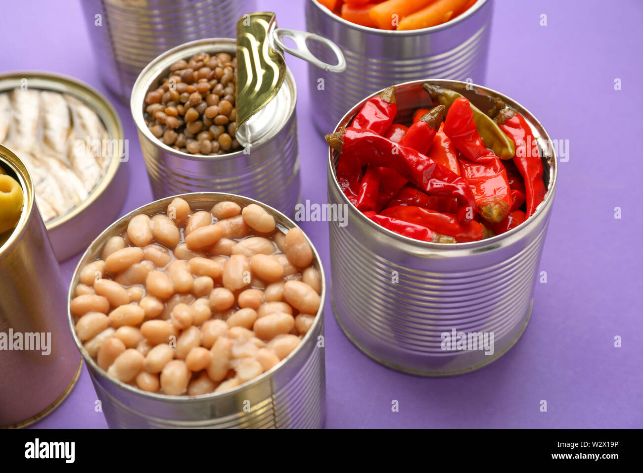 Tin cans with different food on color background Stock Photo - Alamy