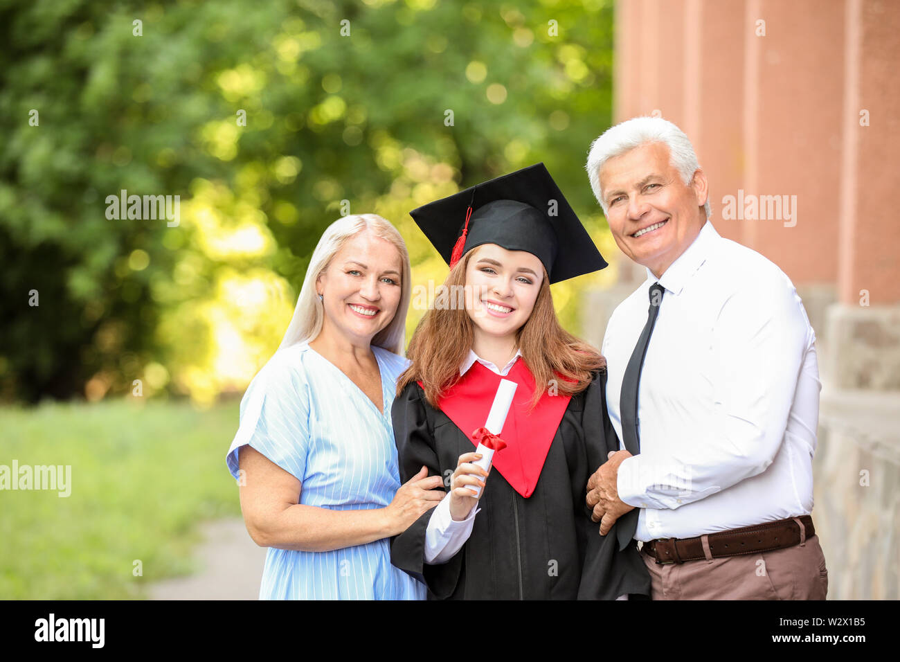 Happy young woman with her parents on graduation day Stock Photo - Alamy