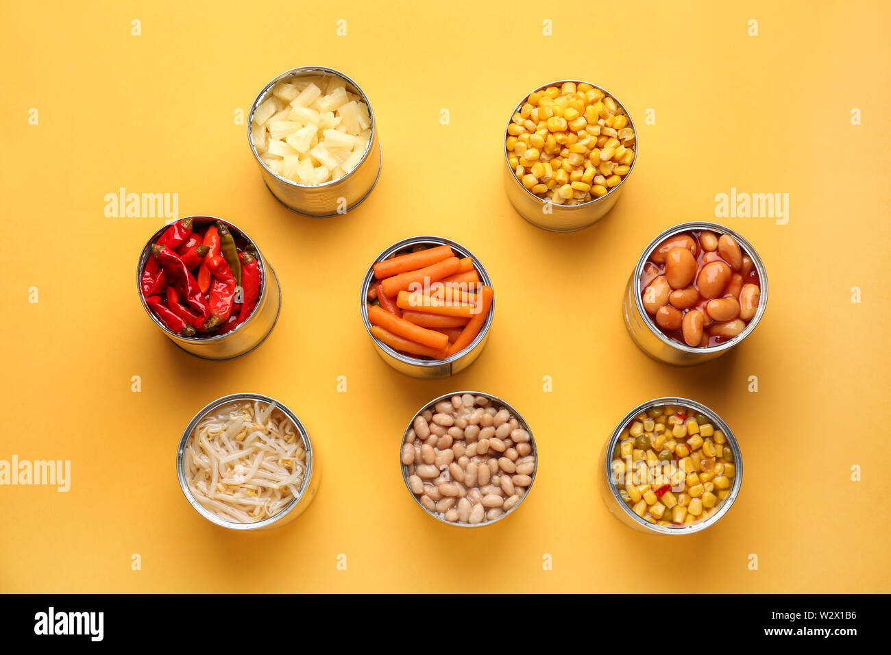 Tin cans with different food on color background Stock Photo - Alamy