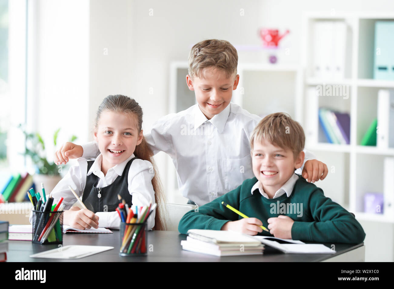 Cute little children doing lessons in classroom Stock Photo - Alamy