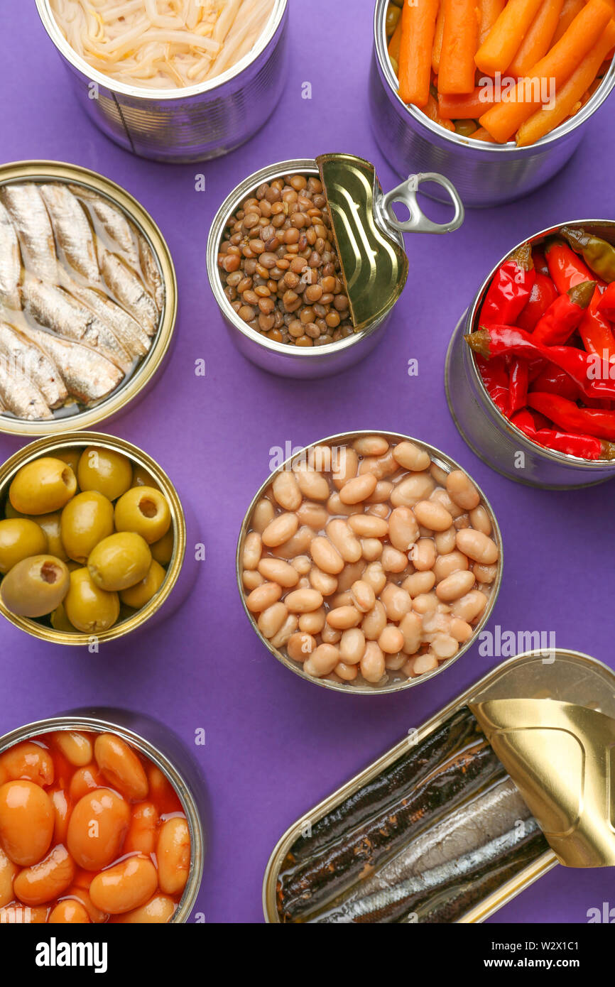 Tin cans with different food on color background Stock Photo - Alamy