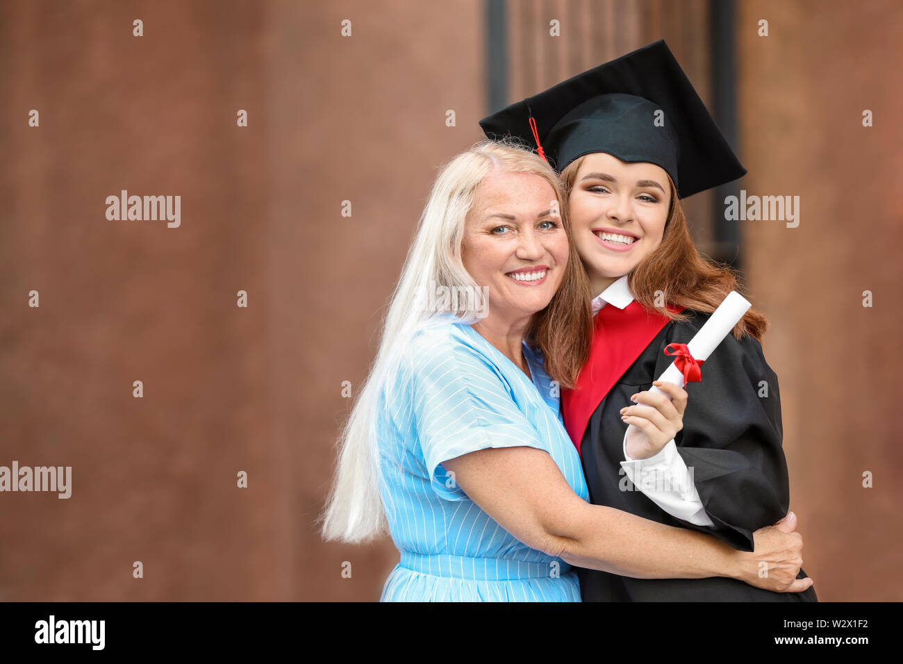 Happy young woman with her mother on graduation day Stock Photo - Alamy