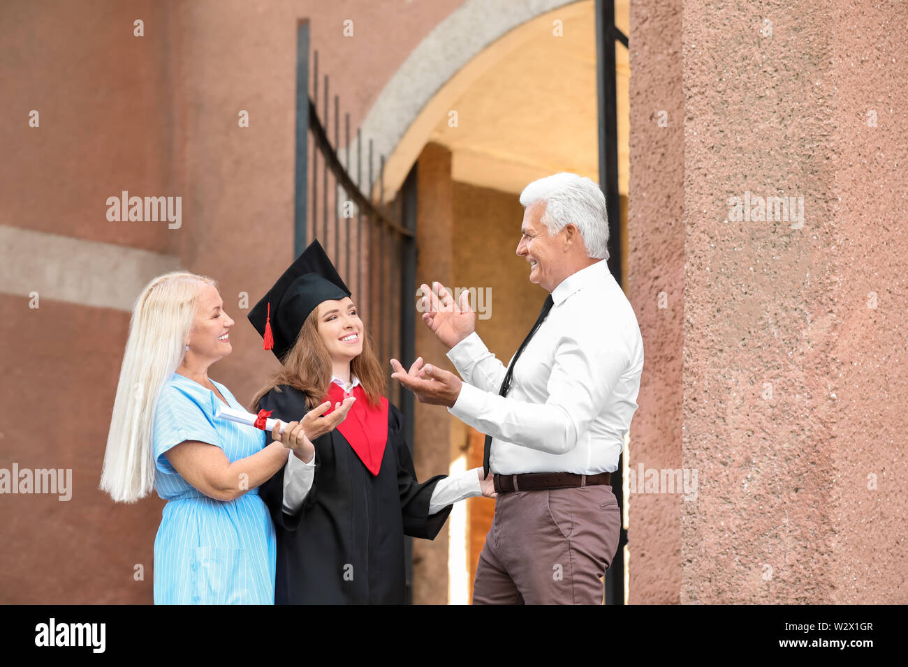Happy young woman with her parents on graduation day Stock Photo - Alamy