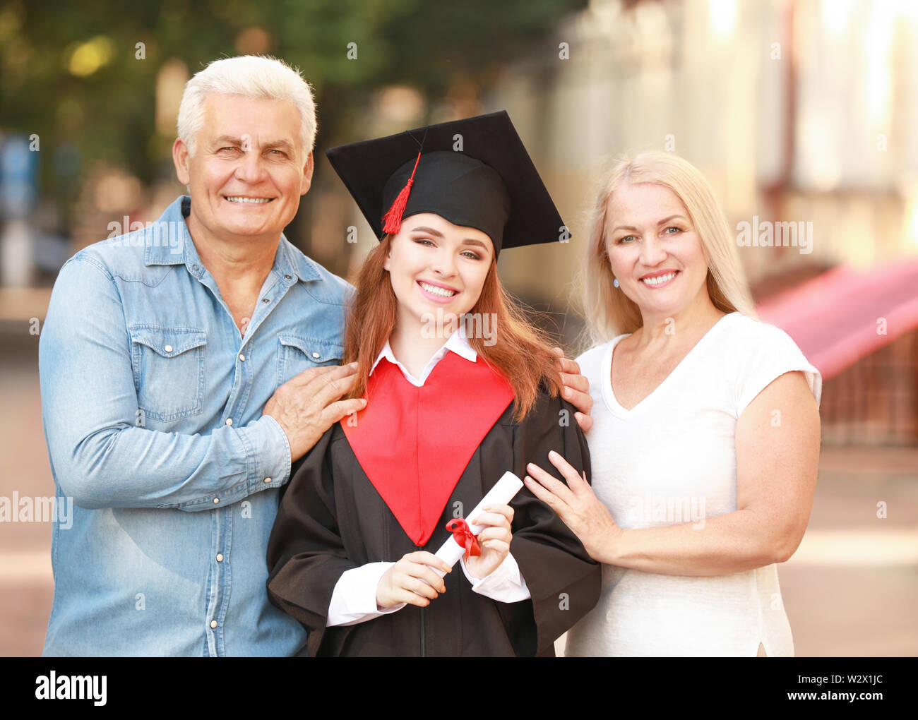 Happy young woman with her parents on graduation day Stock Photo - Alamy