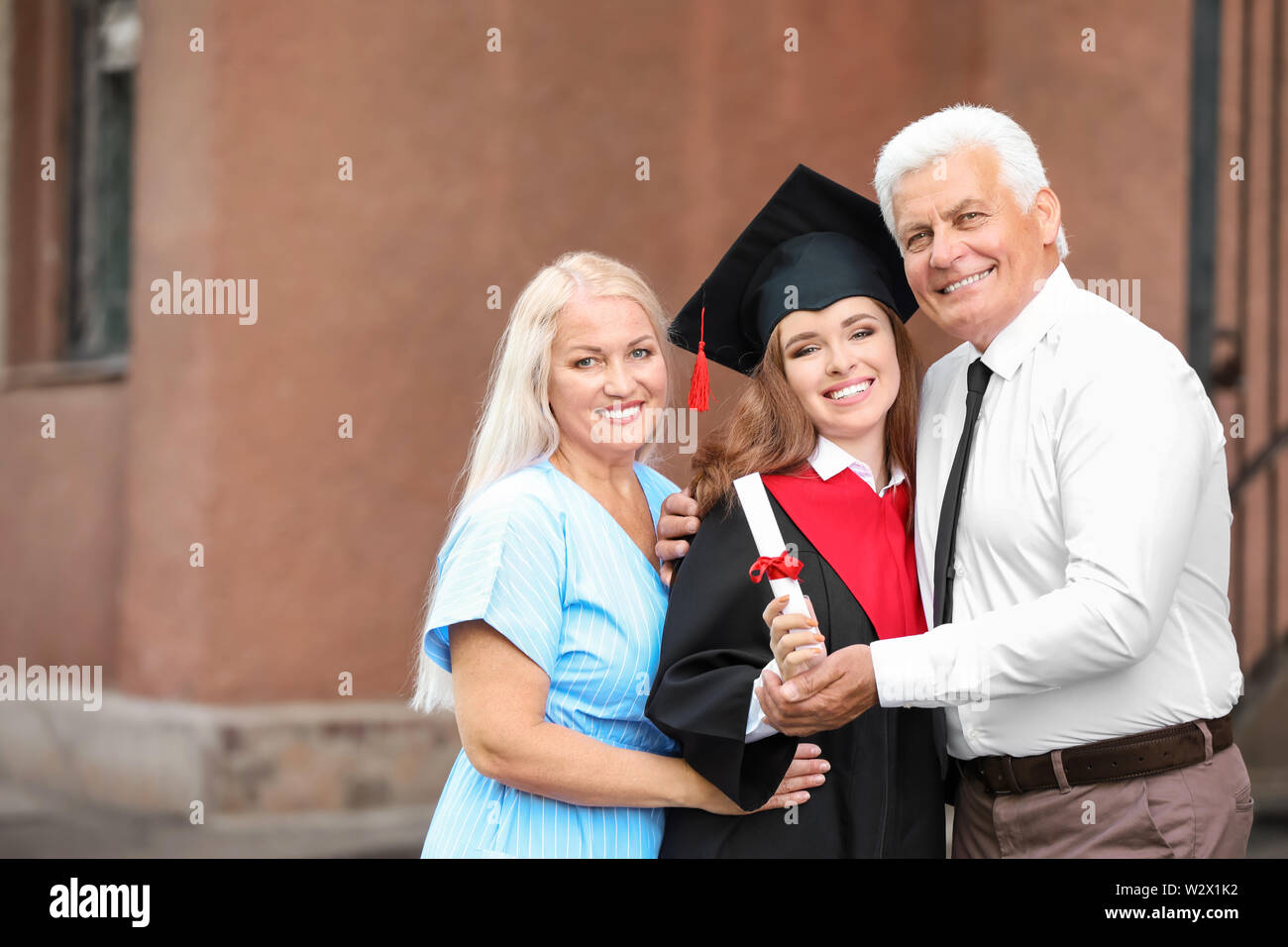 Happy young woman with her parents on graduation day Stock Photo - Alamy