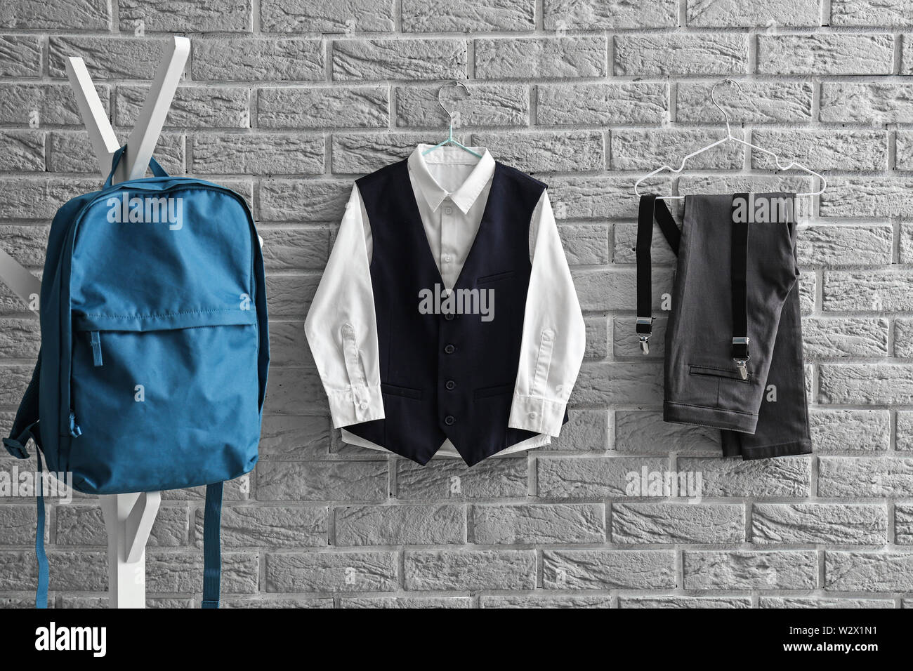 Stylish school uniform with backpack in room Stock Photo - Alamy