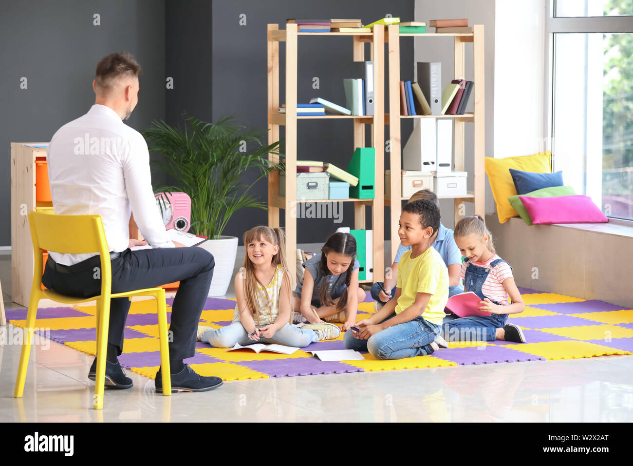 Cute children with teacher in primary school Stock Photo - Alamy