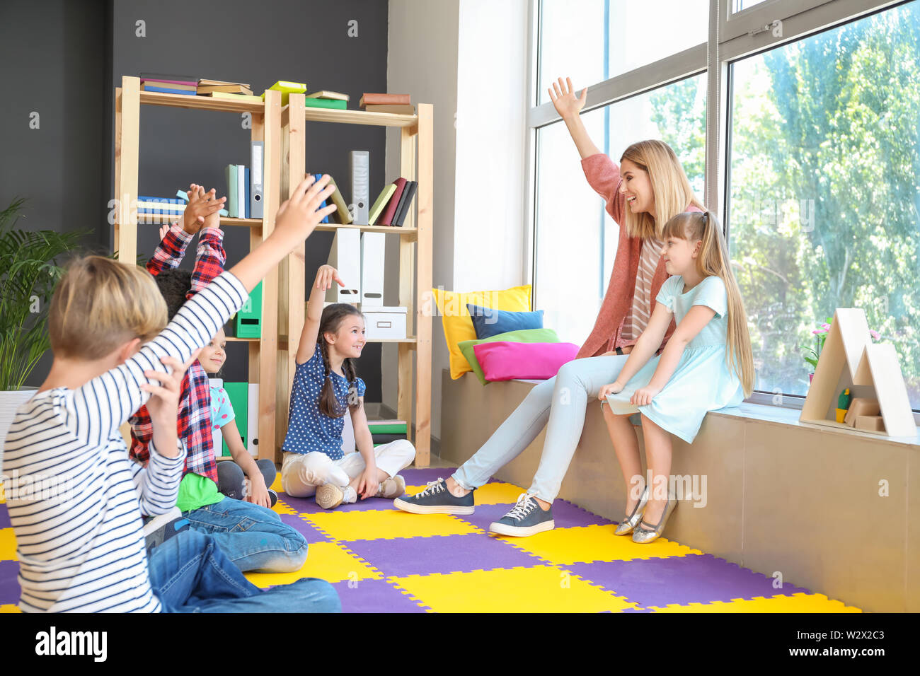 Cute children with teacher in primary school Stock Photo - Alamy