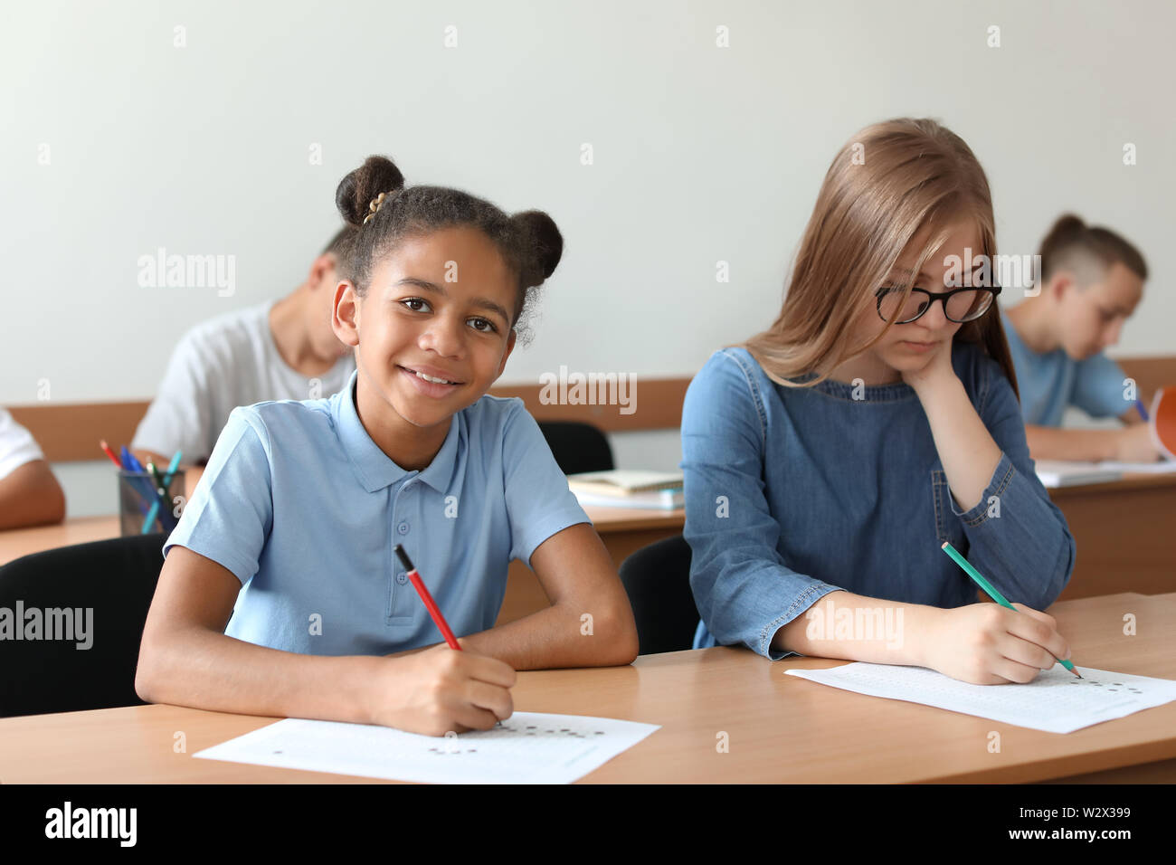 Teenage girls passing school test in classroom Stock Photo - Alamy