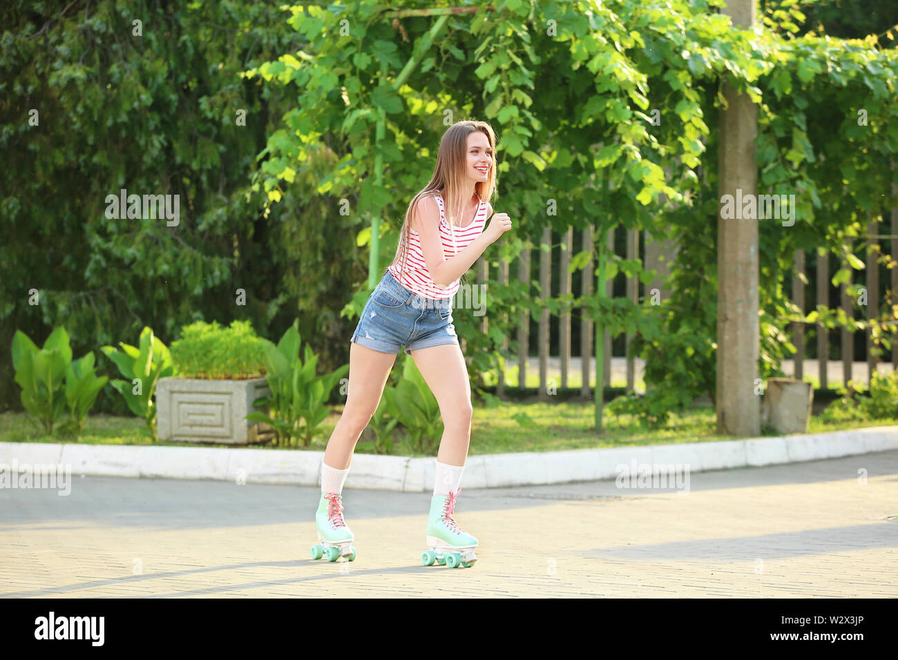 Beautiful young woman on roller skates outdoors Stock Photo - Alamy
