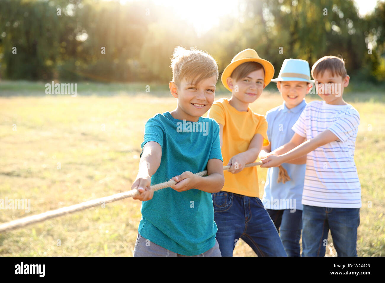 Group of children pulling rope at summer camp Stock Photo - Alamy